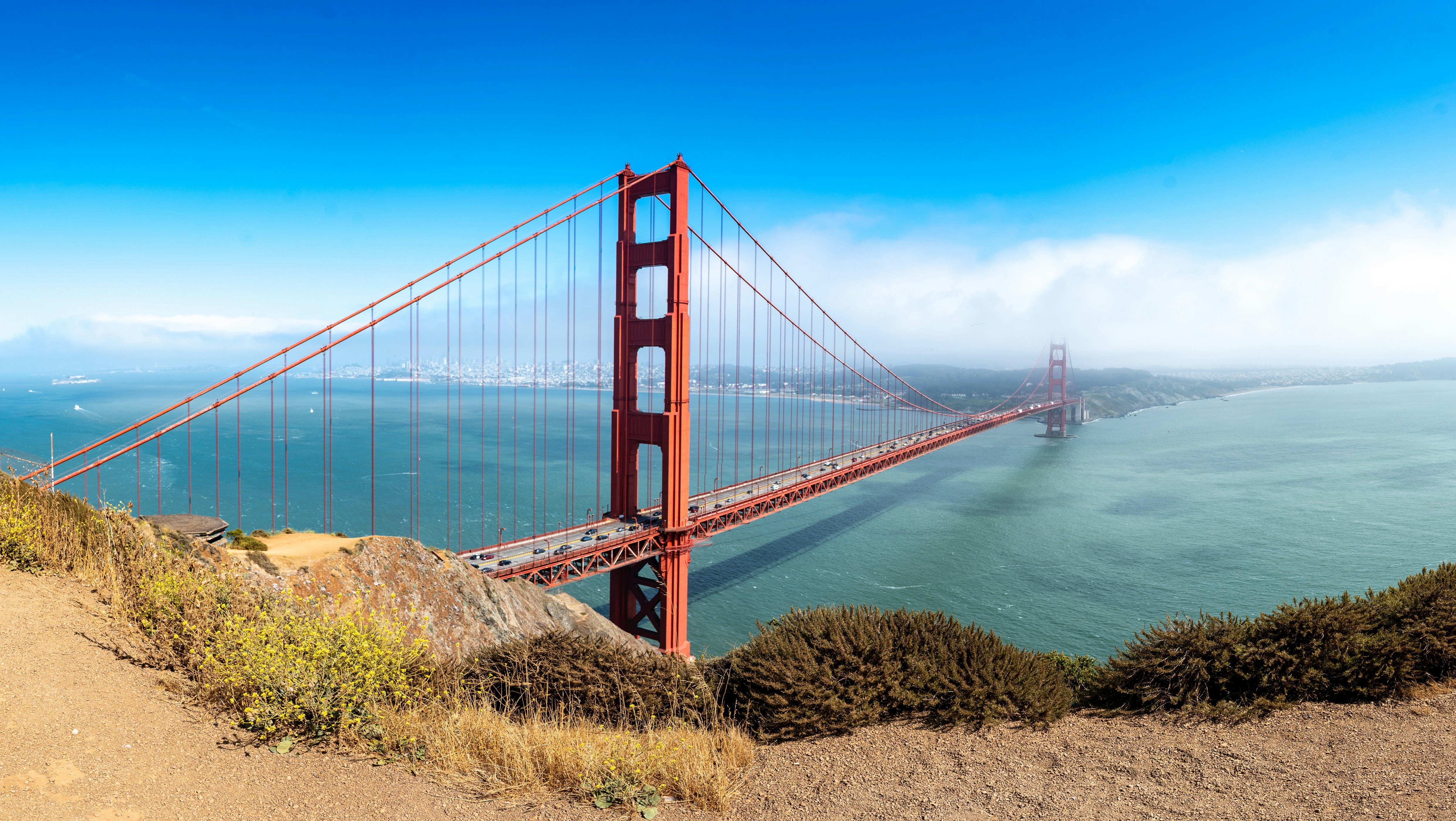 The golden gate bridge spans the blue ocean.