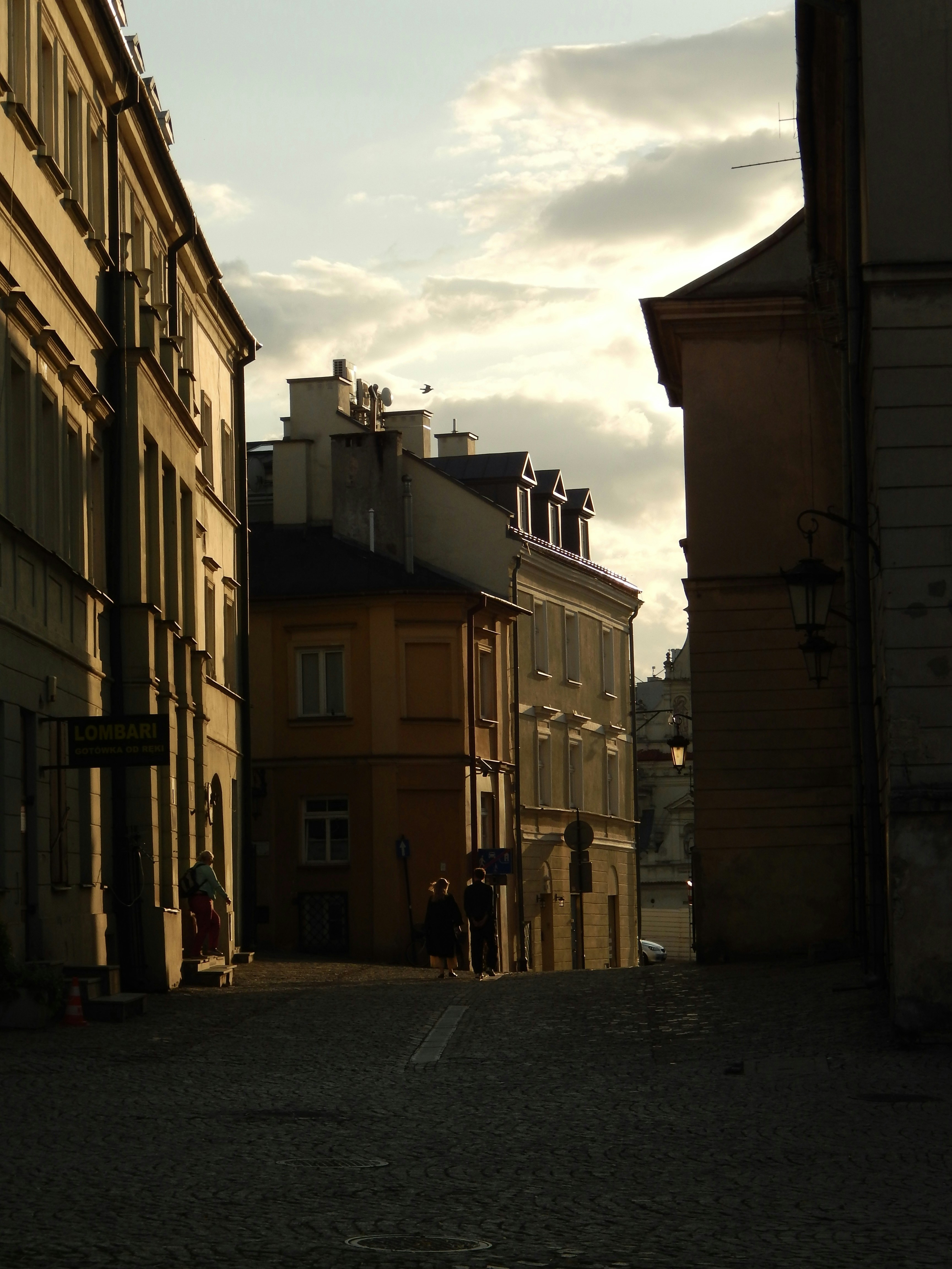 Golden hour bathes a european city street.