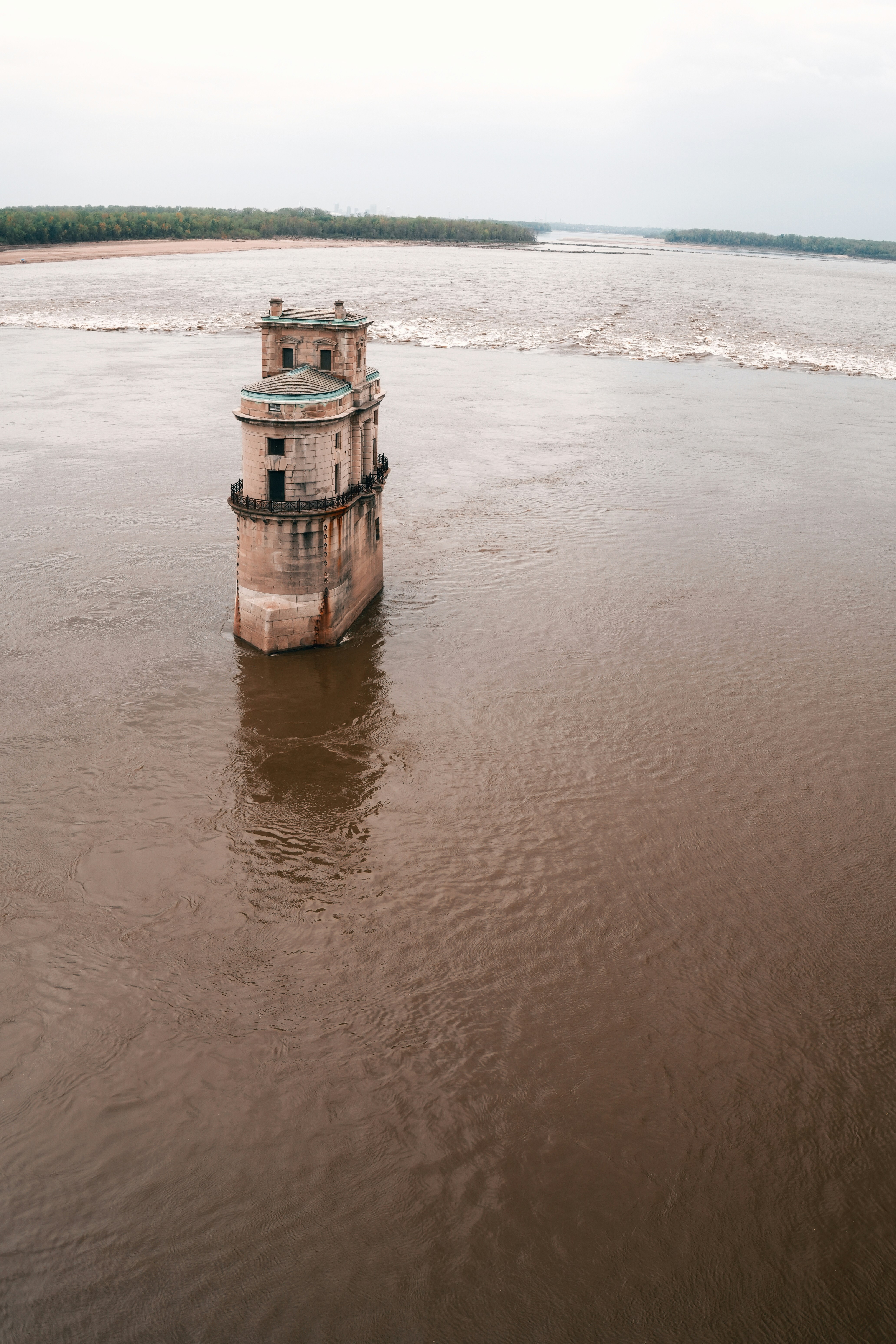 a unique, multi-story structure resembling a lighthouse or a fortified tower. The overall scene evokes a sense of isolation and historical significance, potentially representing a navigational aid or a remnant of a past era.