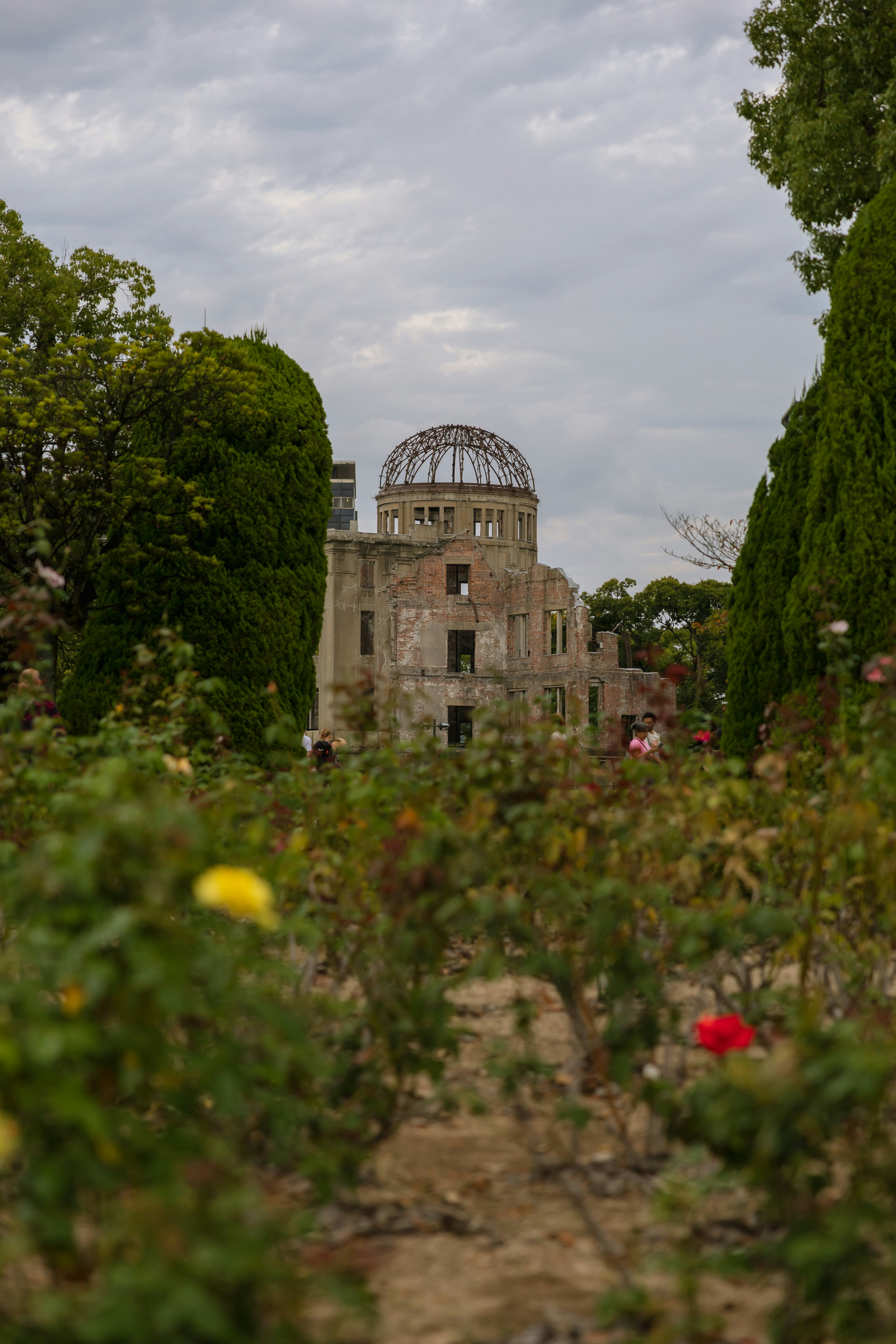 The atomic bomb dome is seen through flowers.