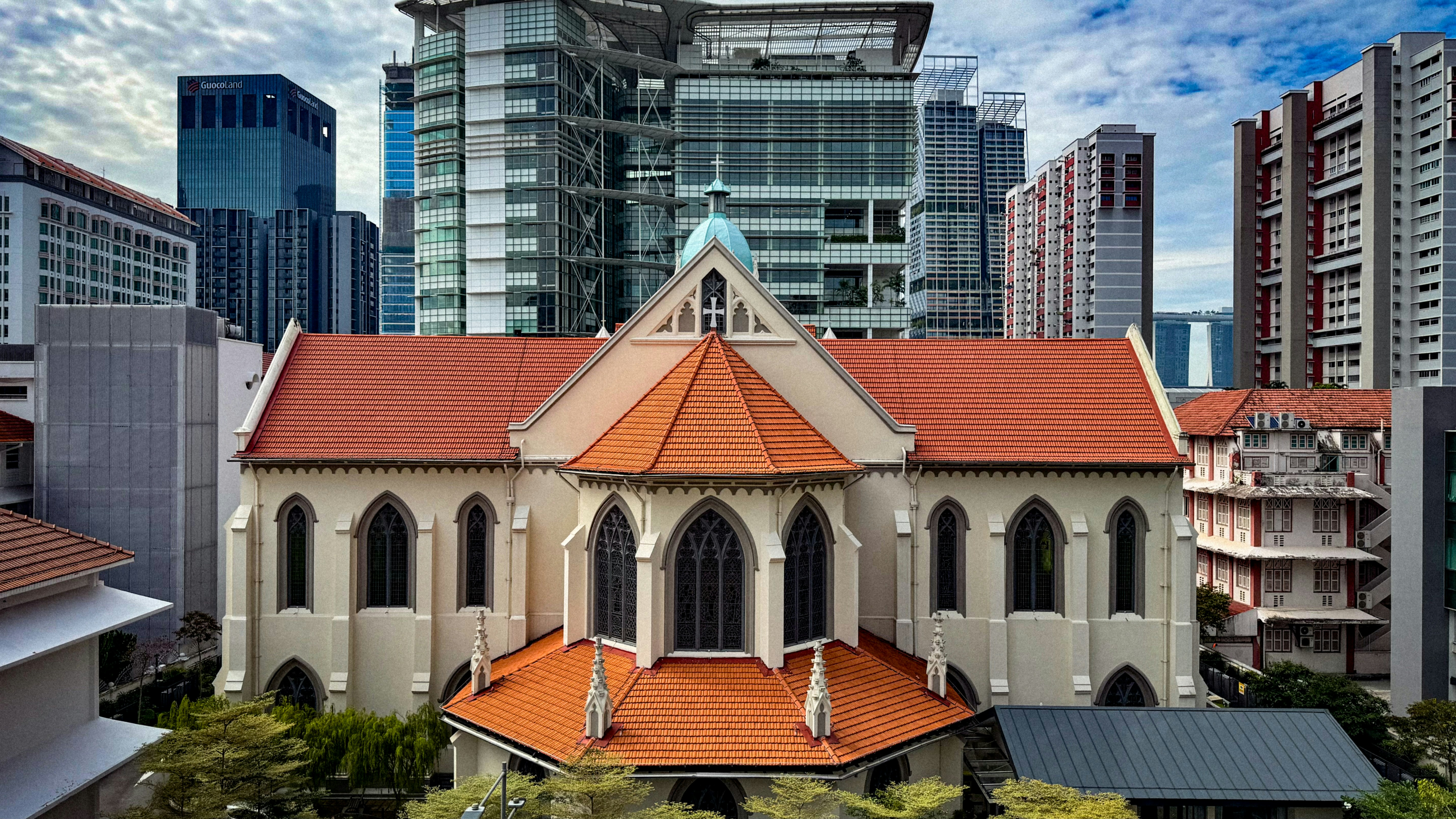 Church stands in front of skyscrapers.
