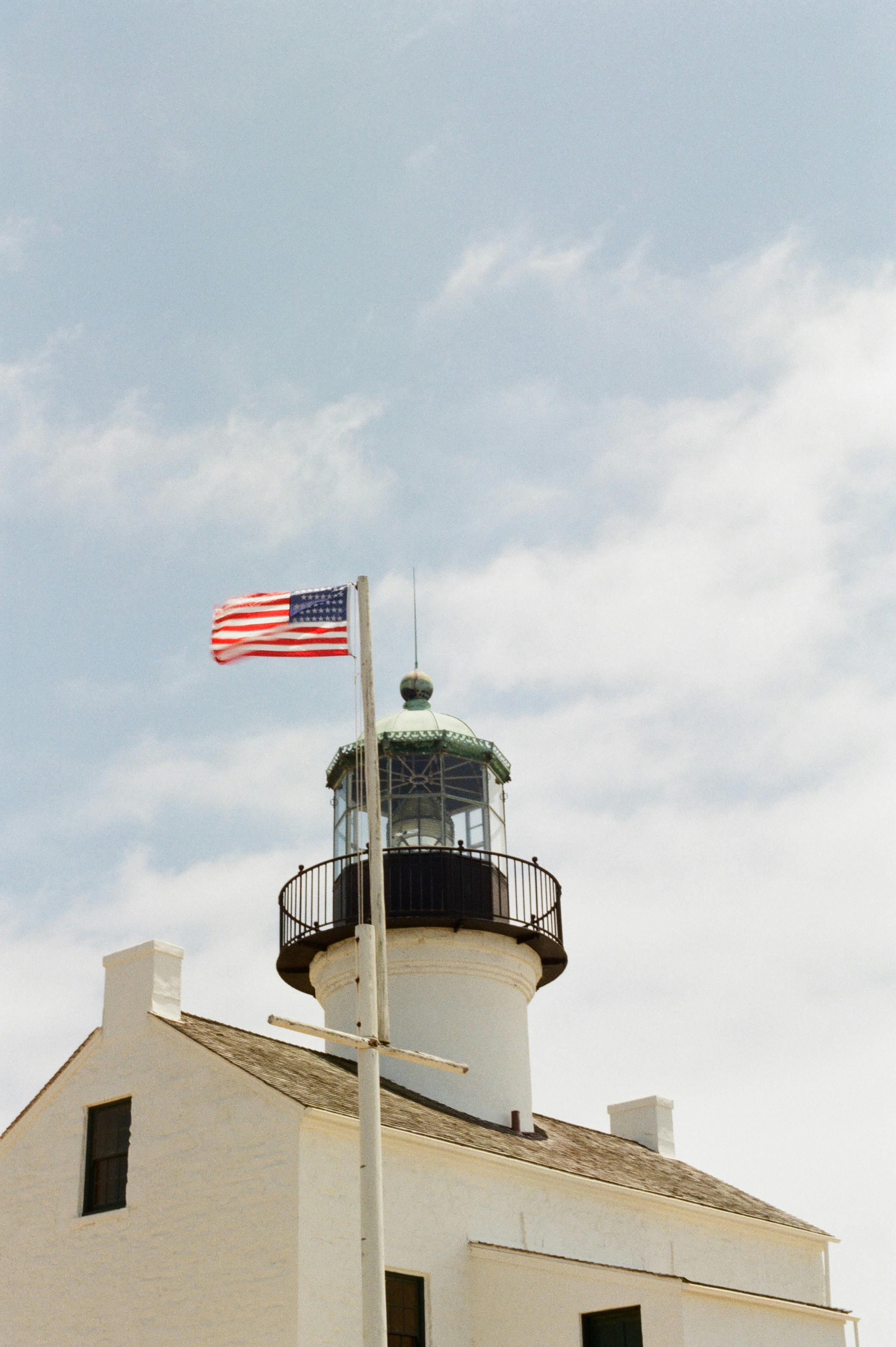 A lighthouse stands tall with an american flag. photo – Free Lighthouse ...