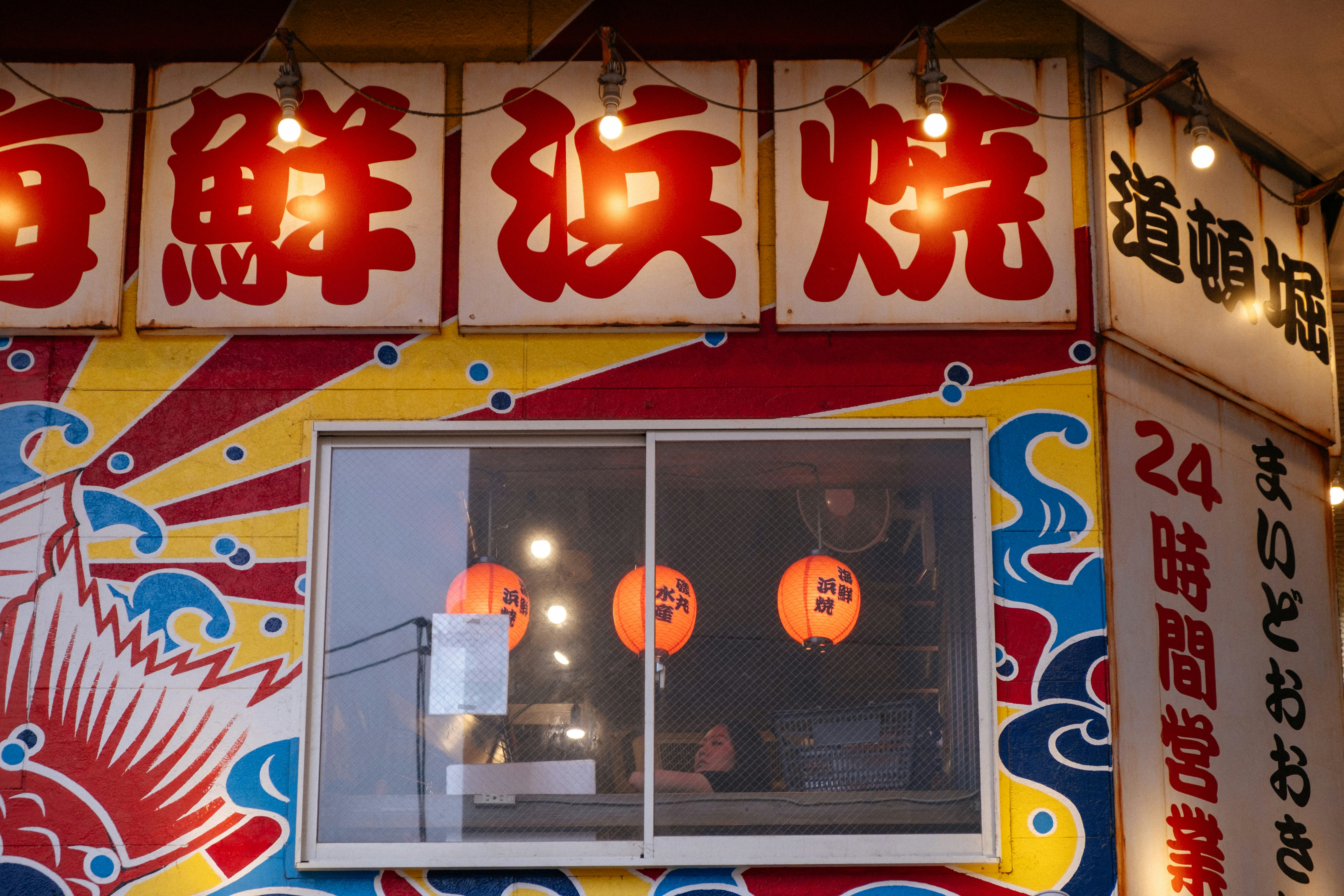 Lantern-lit Window Amid a Kaleidoscopic Festival Façade