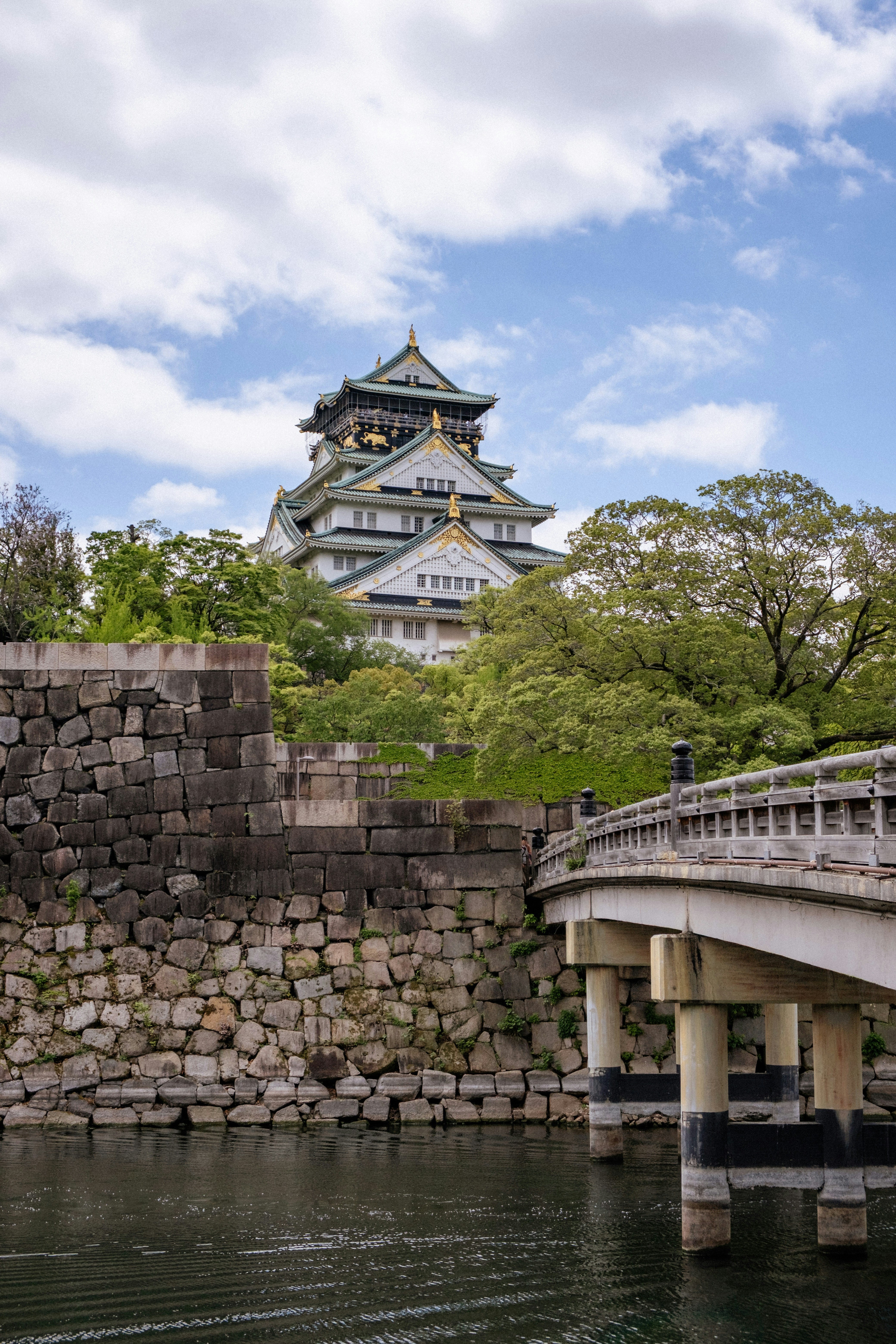 Osaka castle is framed by a bridge and stonework.