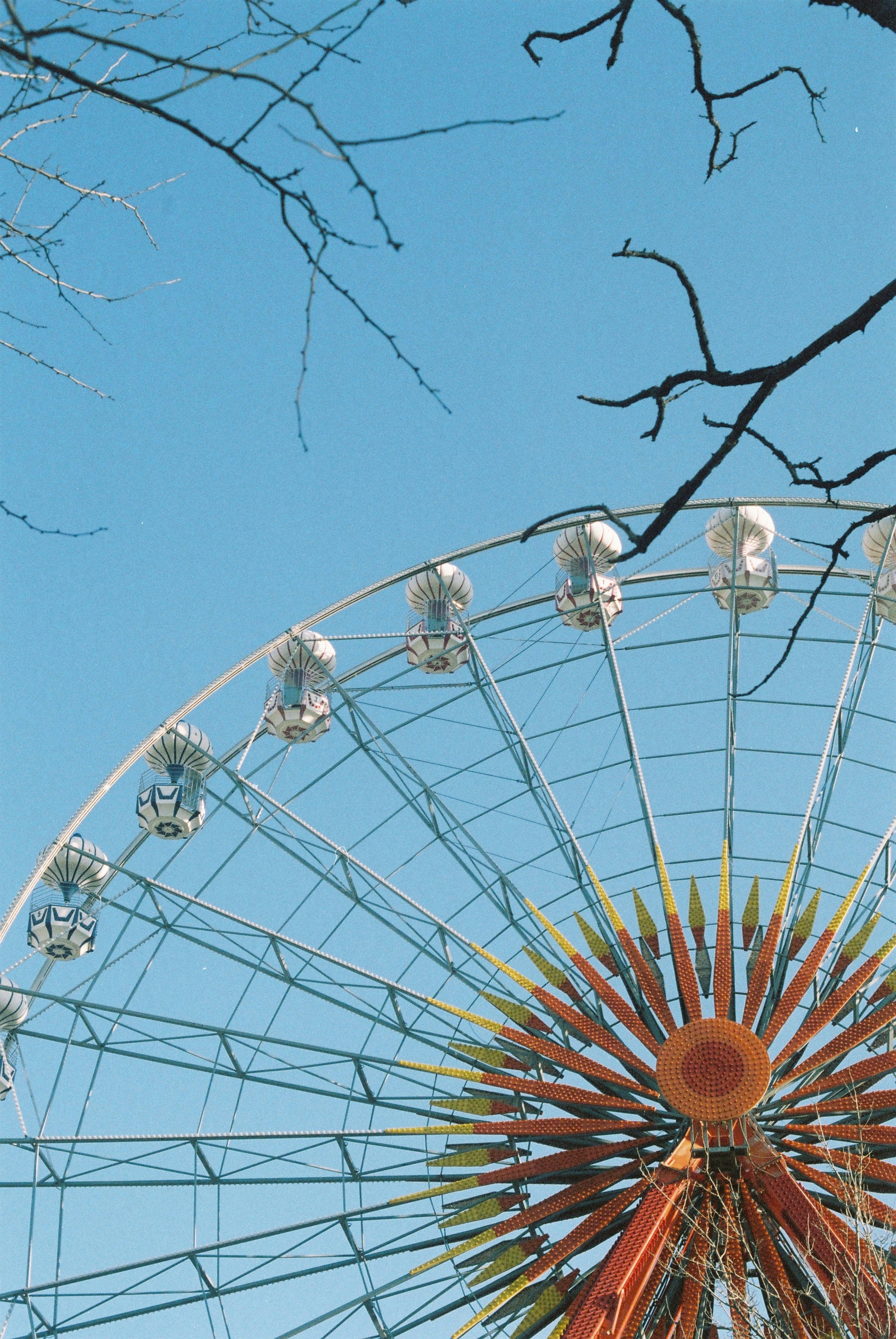 A ferris wheel stands beneath a blue sky.