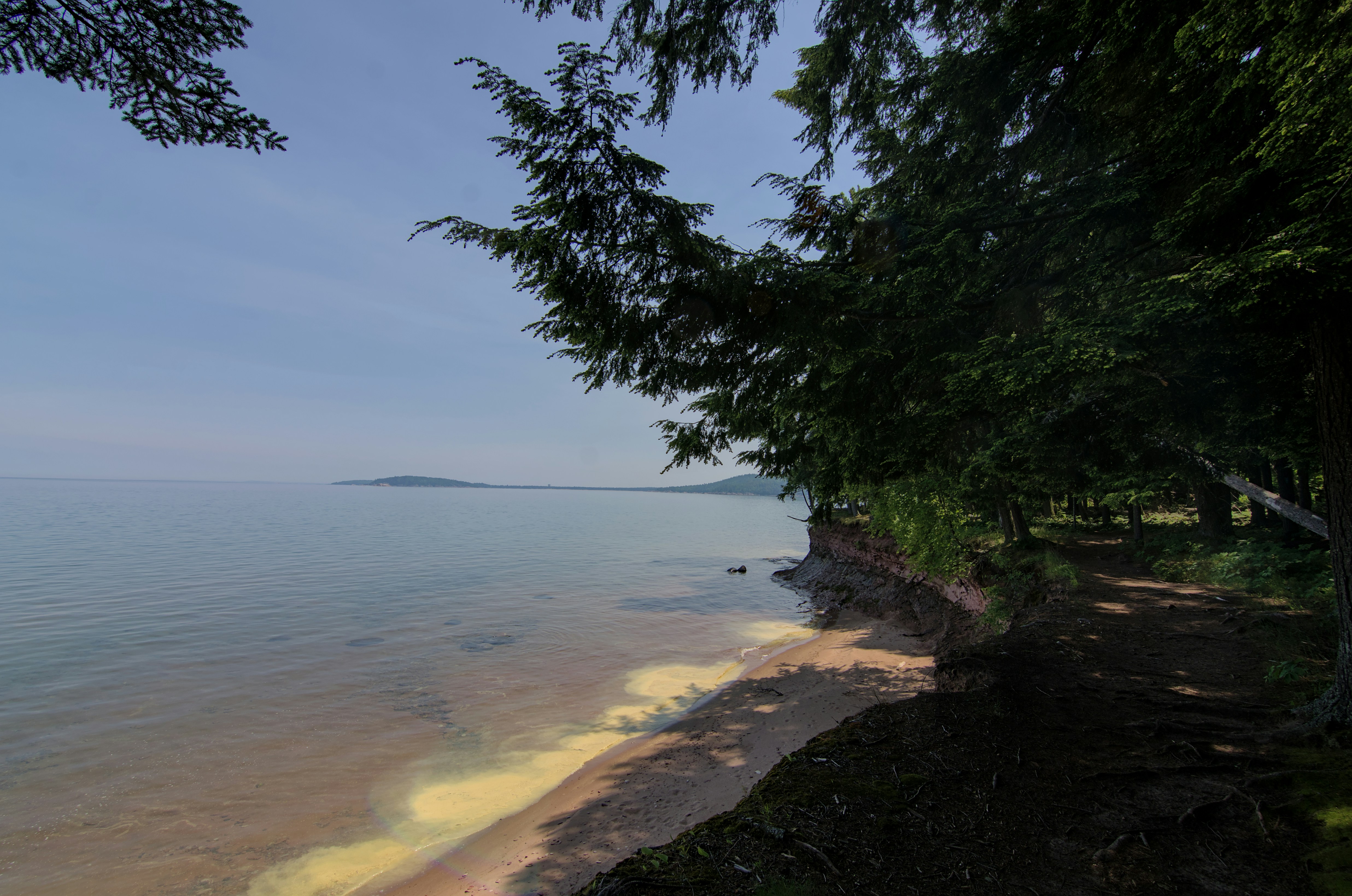 The shoreline meets the water under a bright sky.