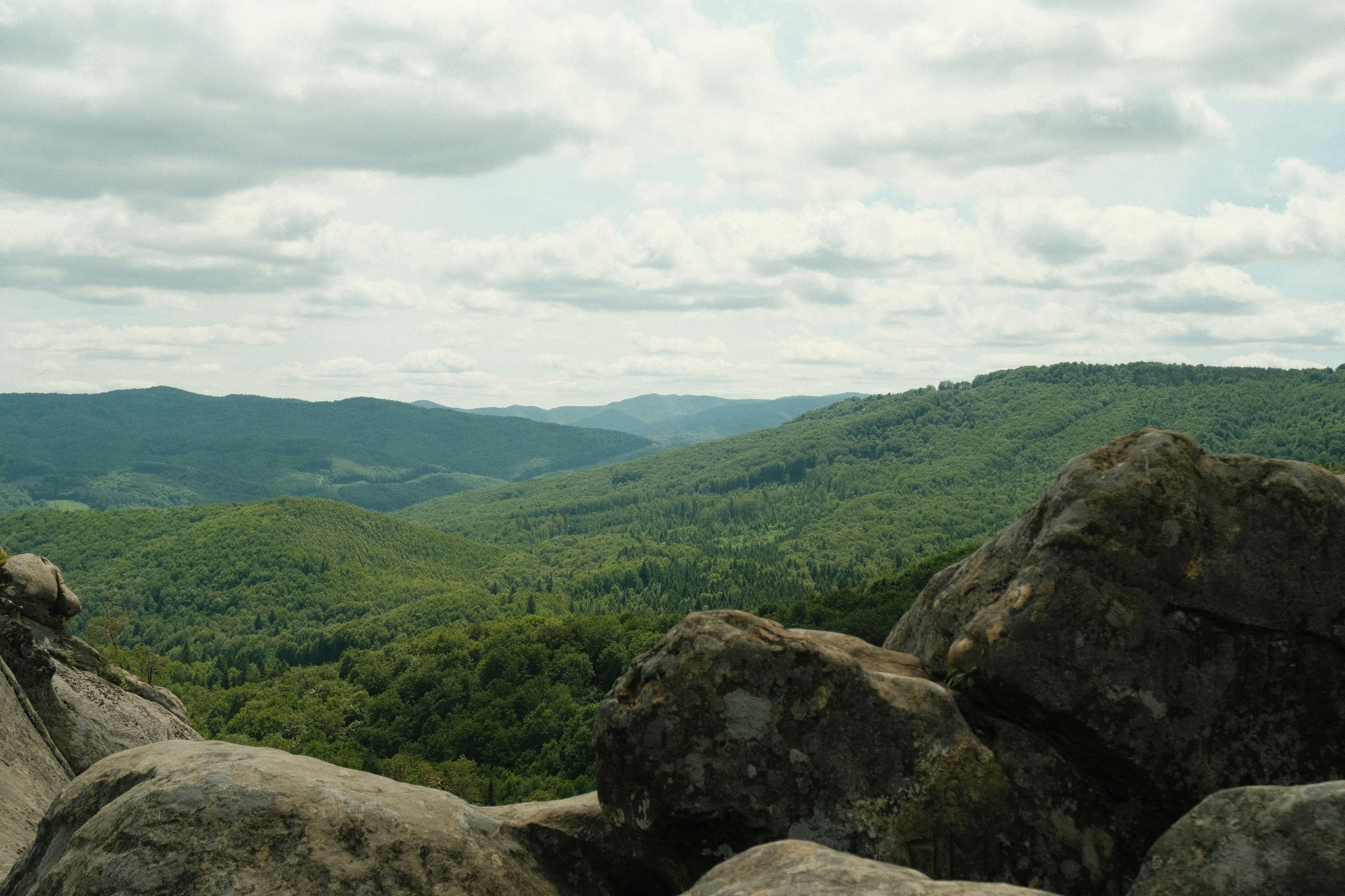 Green mountains stretch under a cloudy sky.