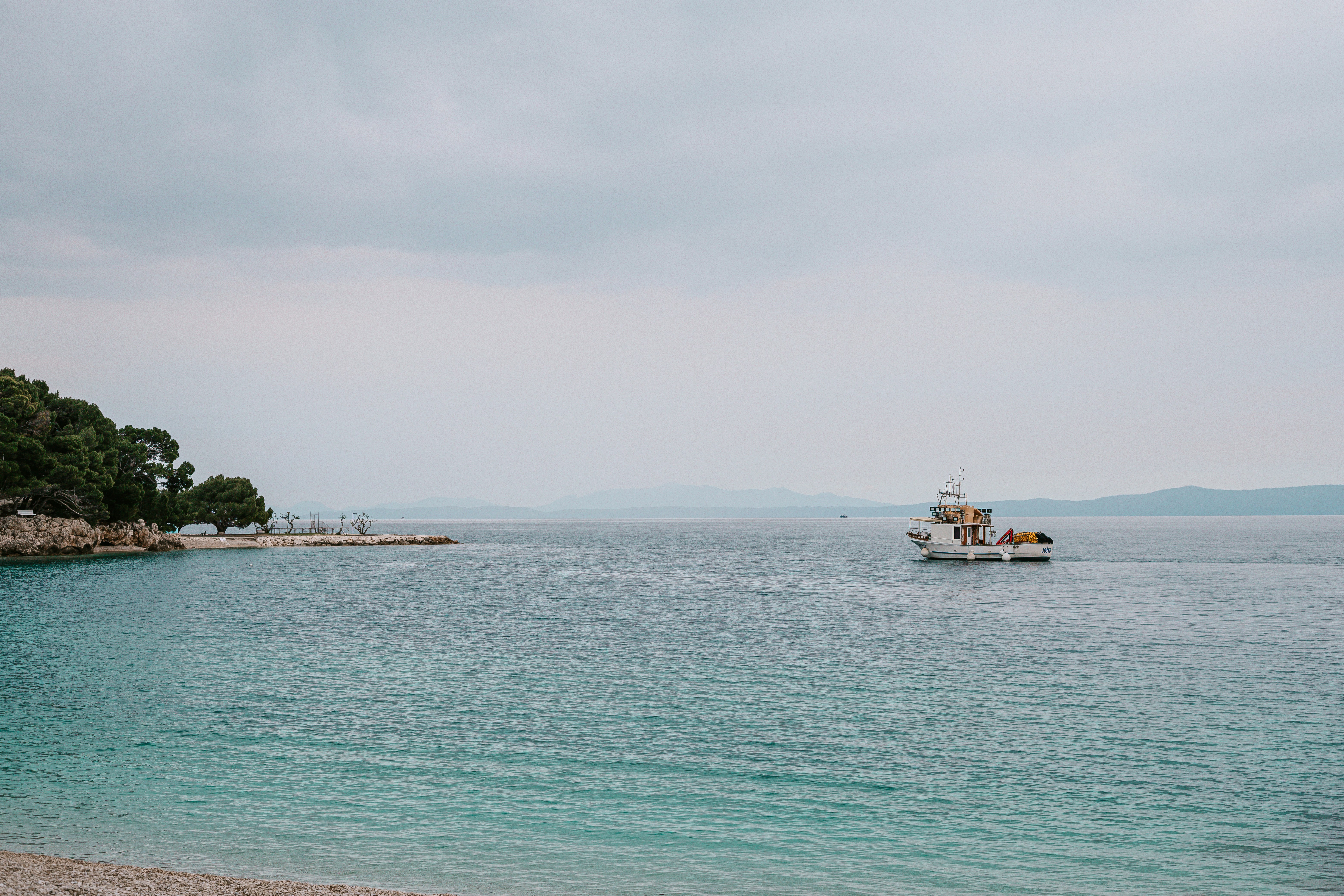 A boat sails on a calm ocean.