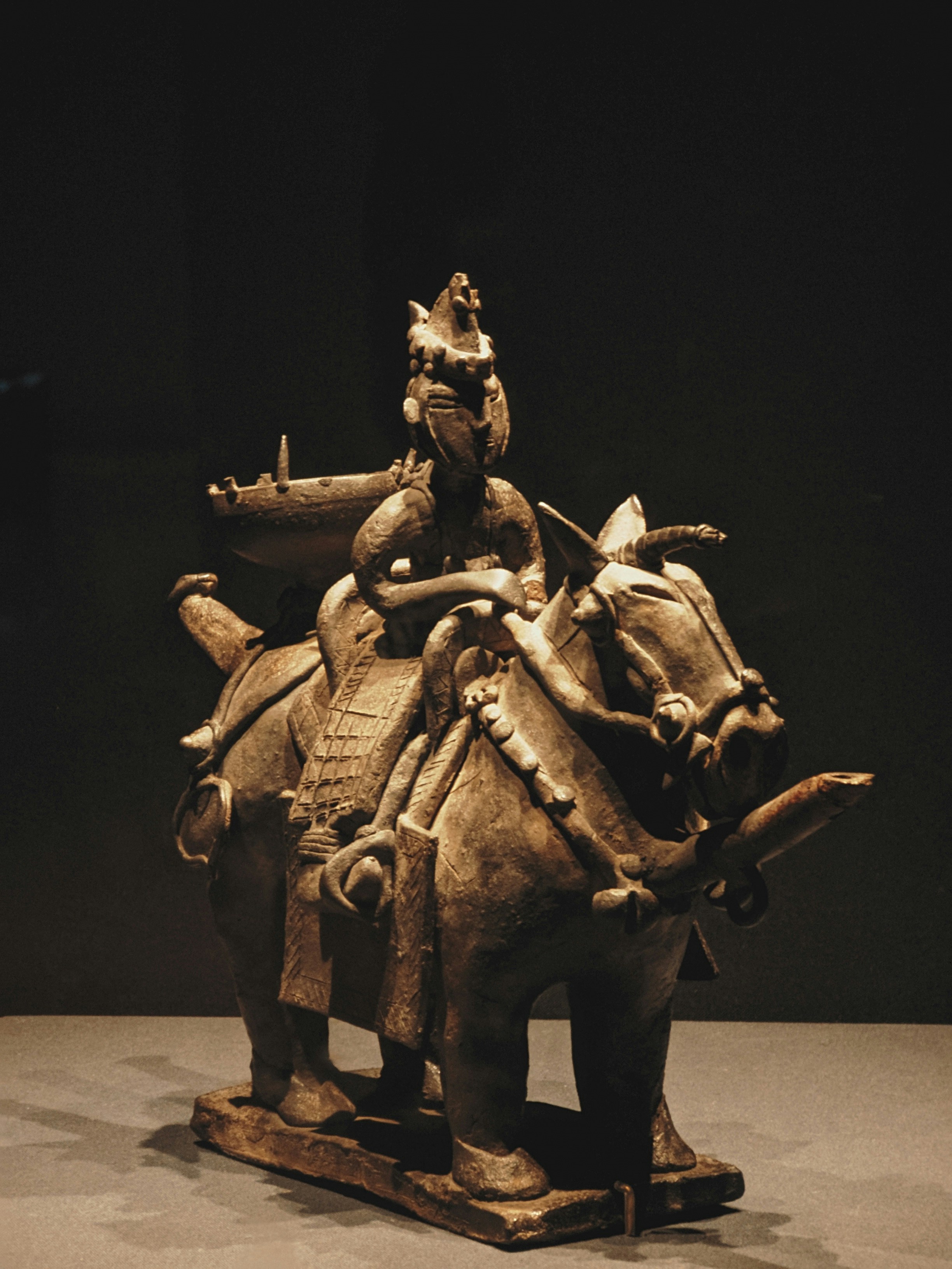 Ancient terracotta sculpture of a warrior on horseback.