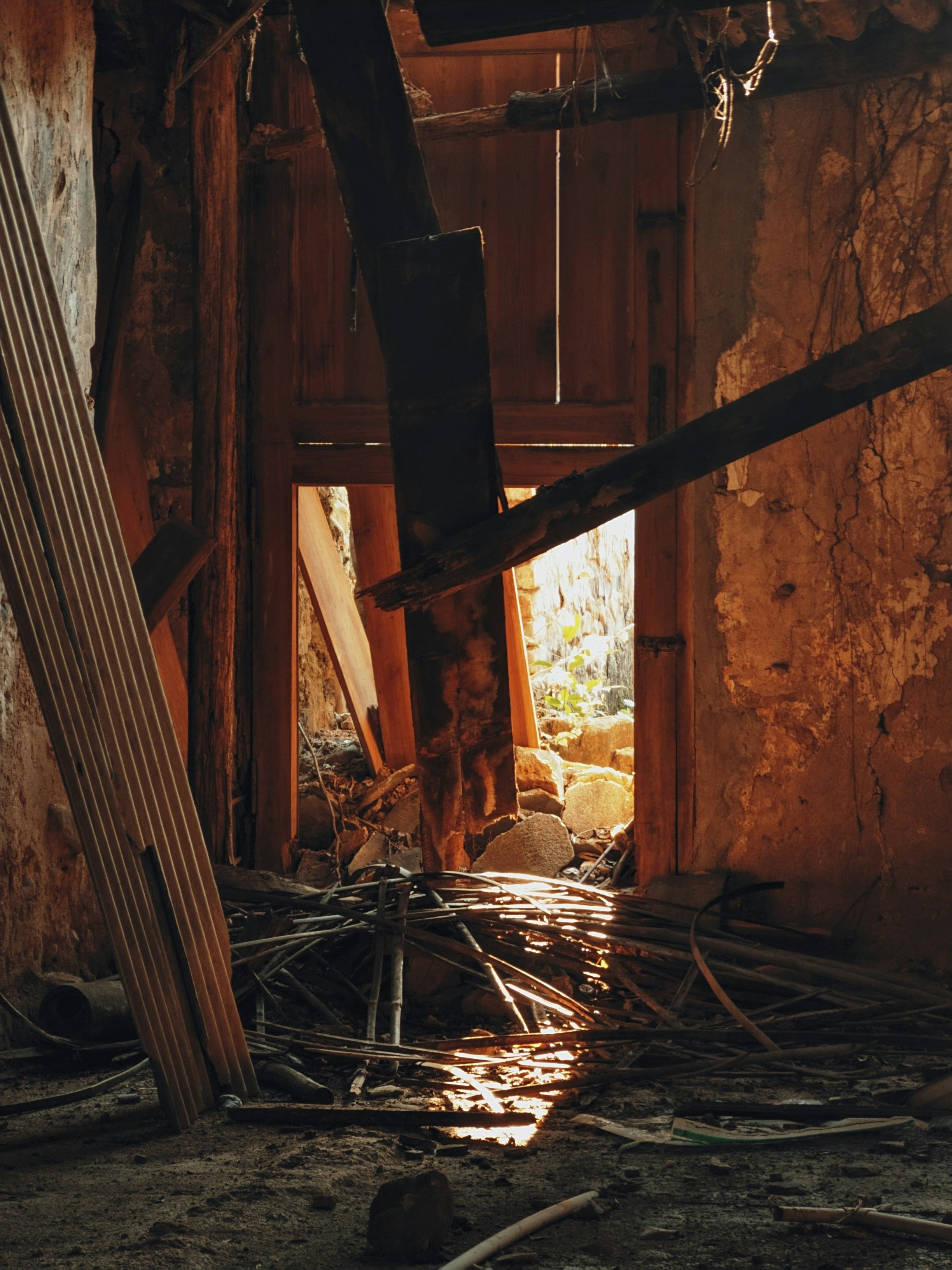 Inside a decaying building with light shining through.