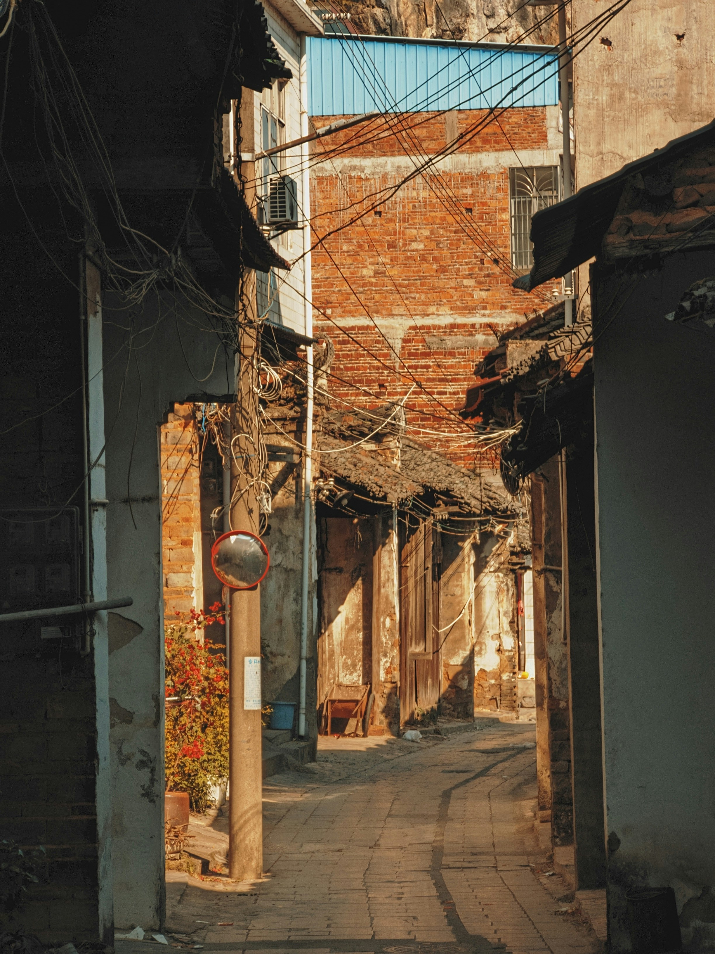 A narrow alleyway shows dilapidated buildings.