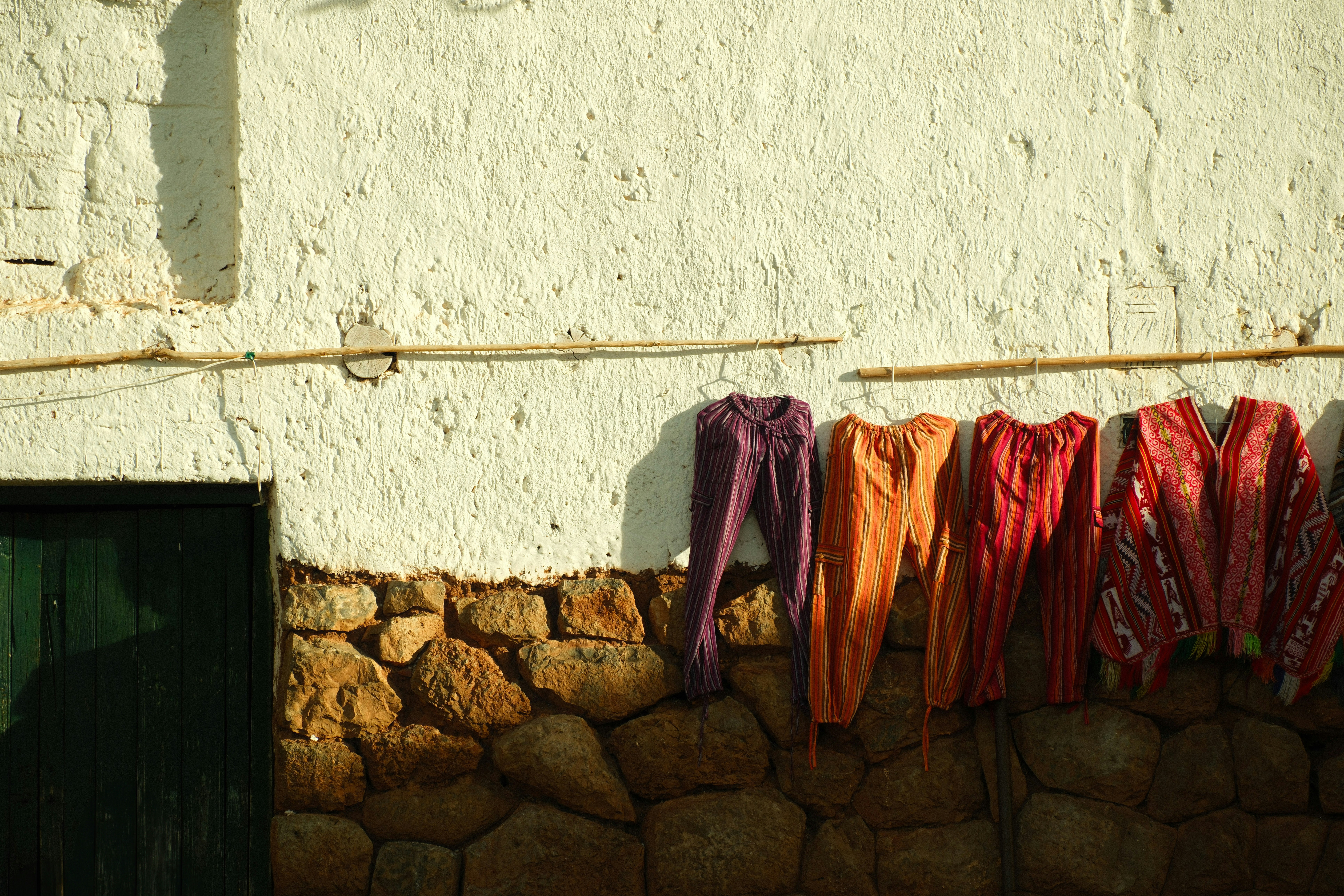Clothes hang on a line outside a building.