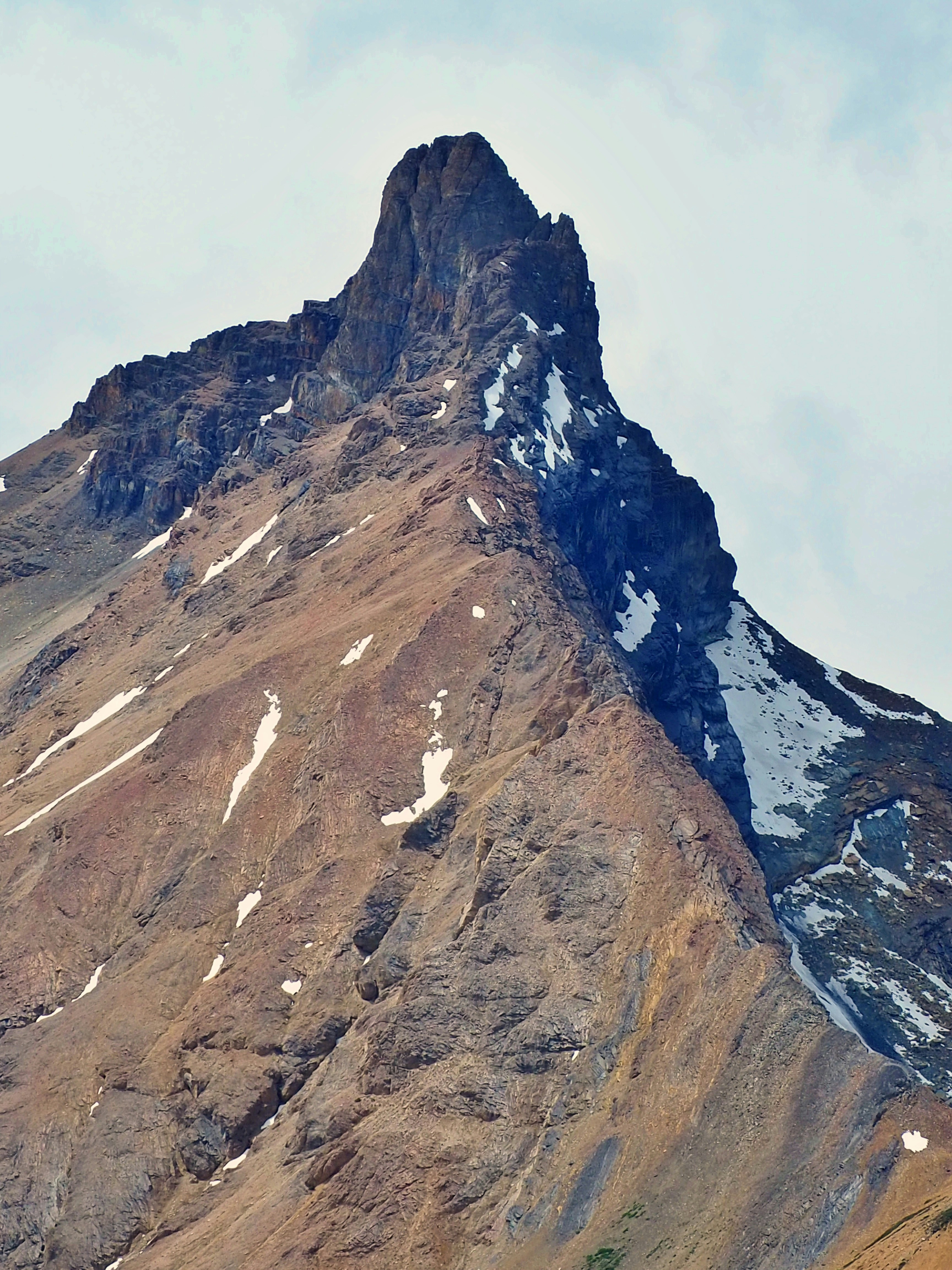 A majestic mountain peak with patches of snow.
