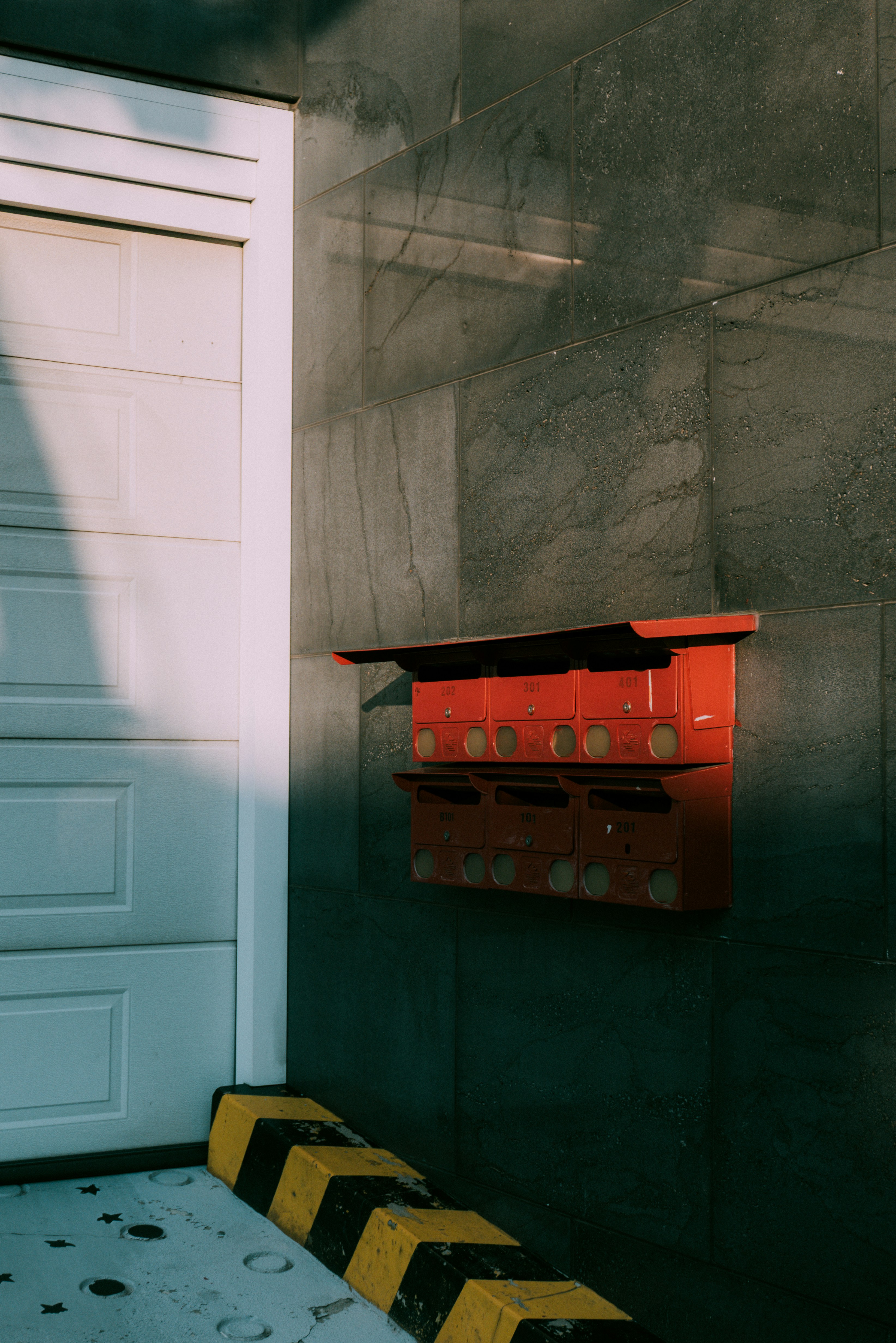 A red mailbox sits on a dark grey wall.