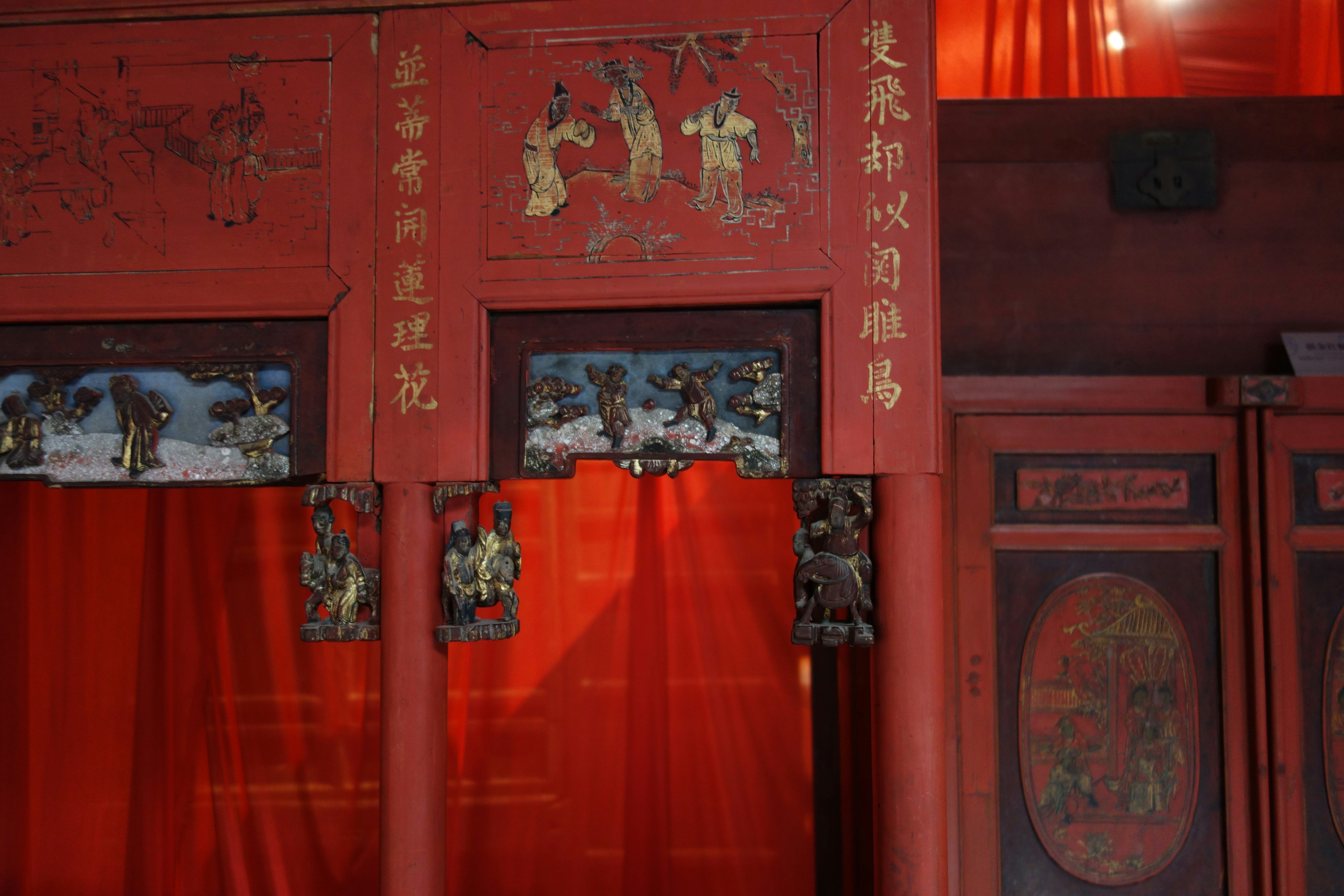 Red walls and intricate gold details in a temple.