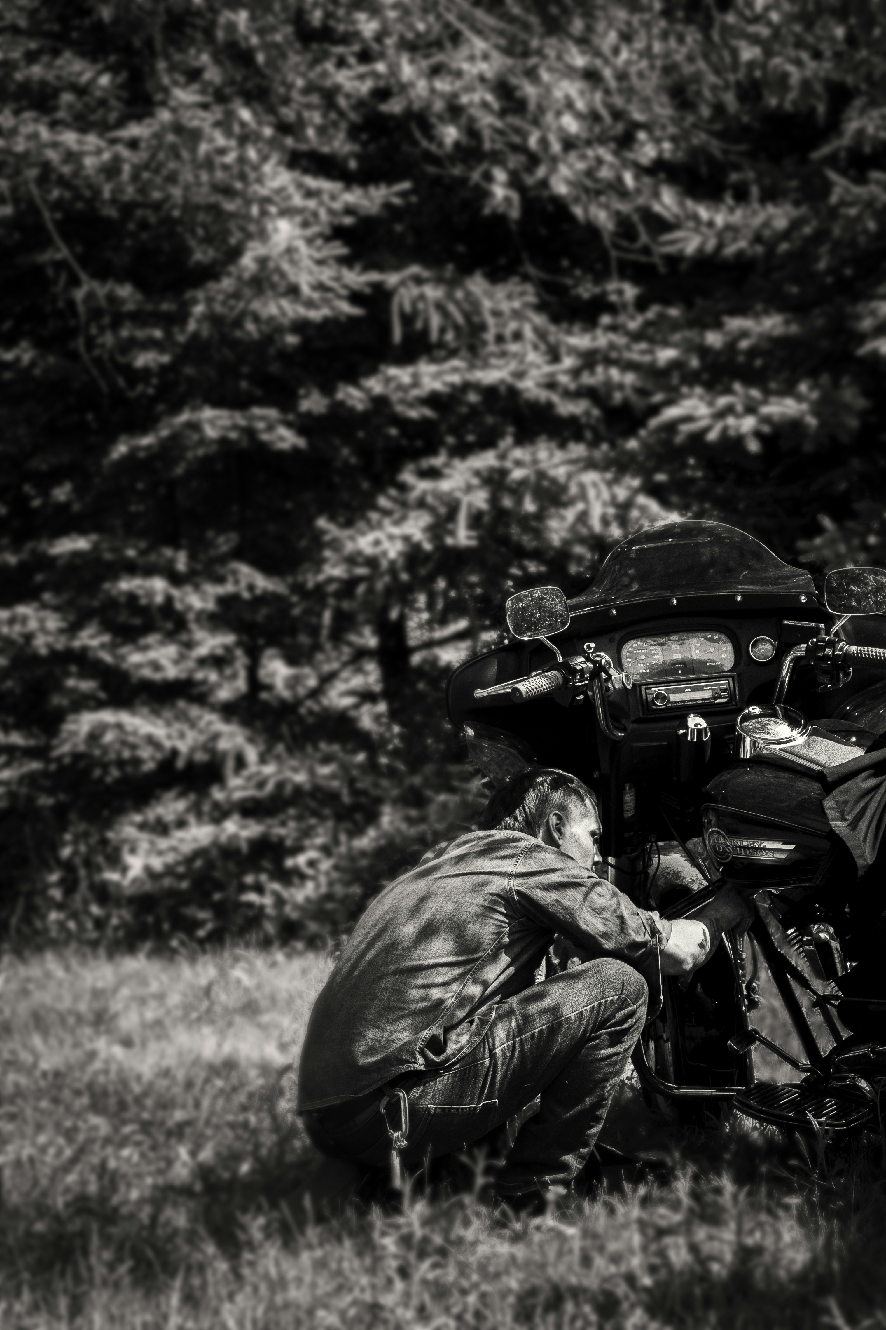 a very unique person who buys second-hand old-fashioned Harley-Davidson and built it himself and ride it wherever he wants to go. Such a talented and spiritual person. | A person is fixing their motorcycle.
