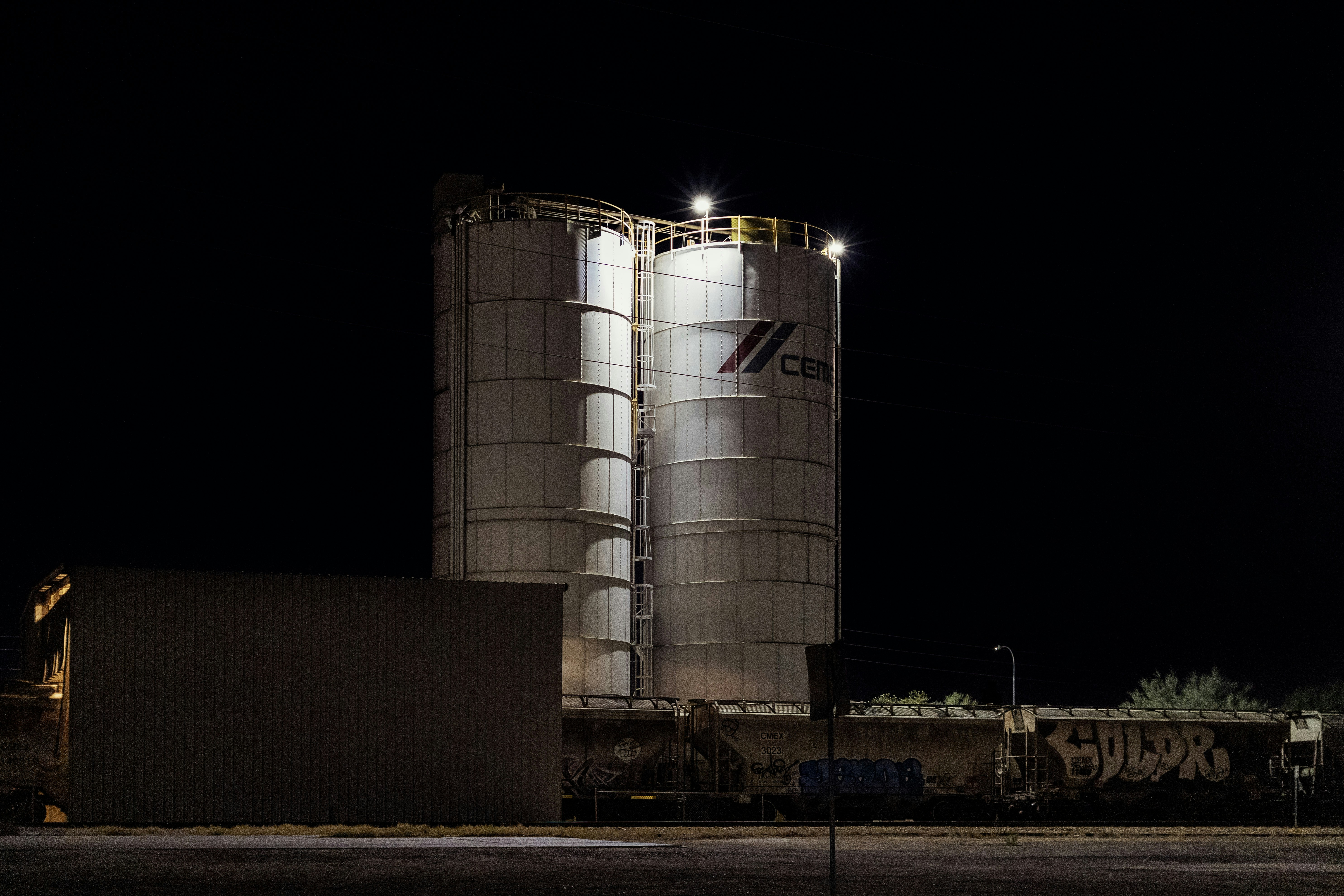 A lighted industrial building in the night.