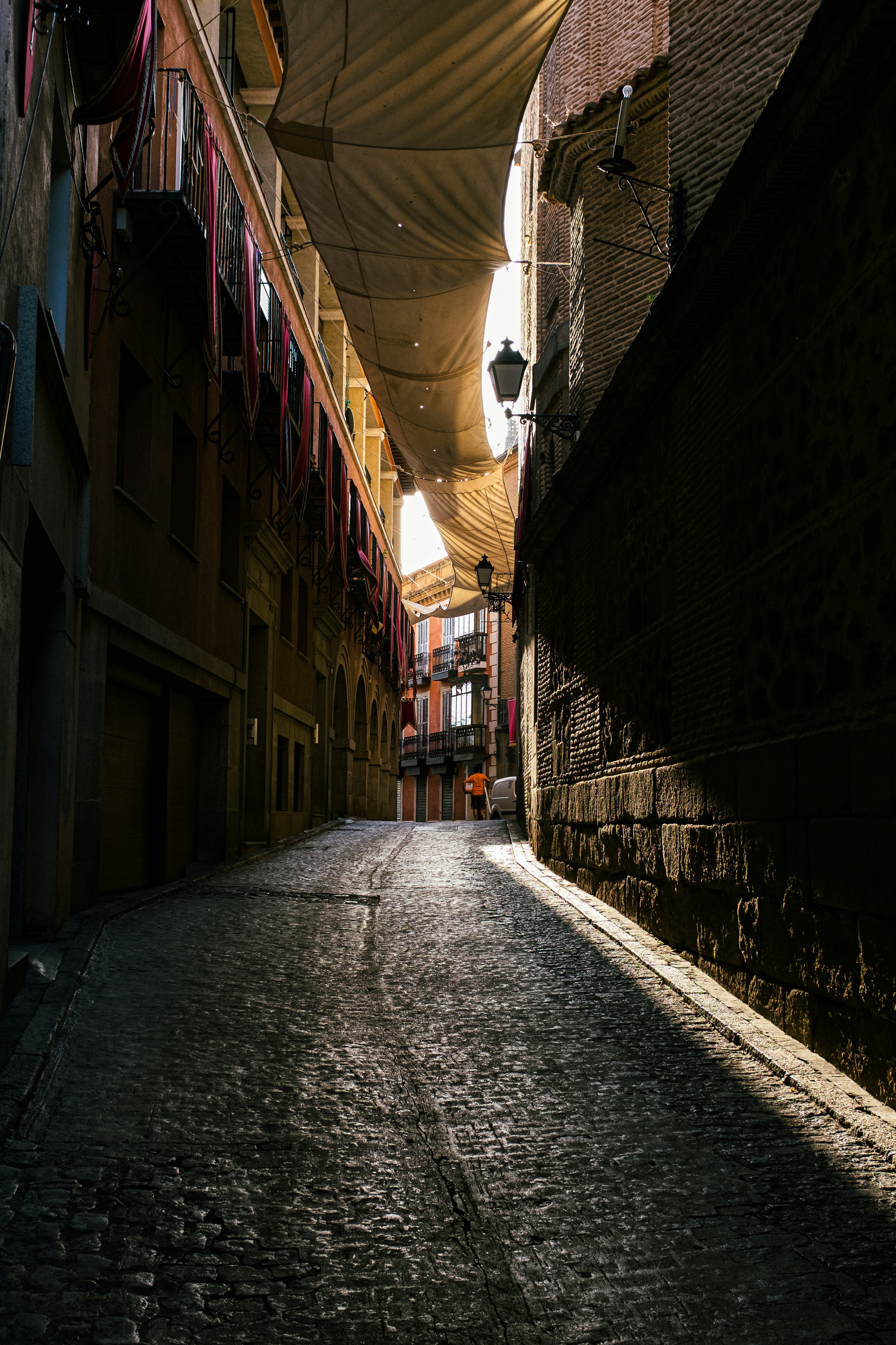 A cobblestone street is seen between buildings.