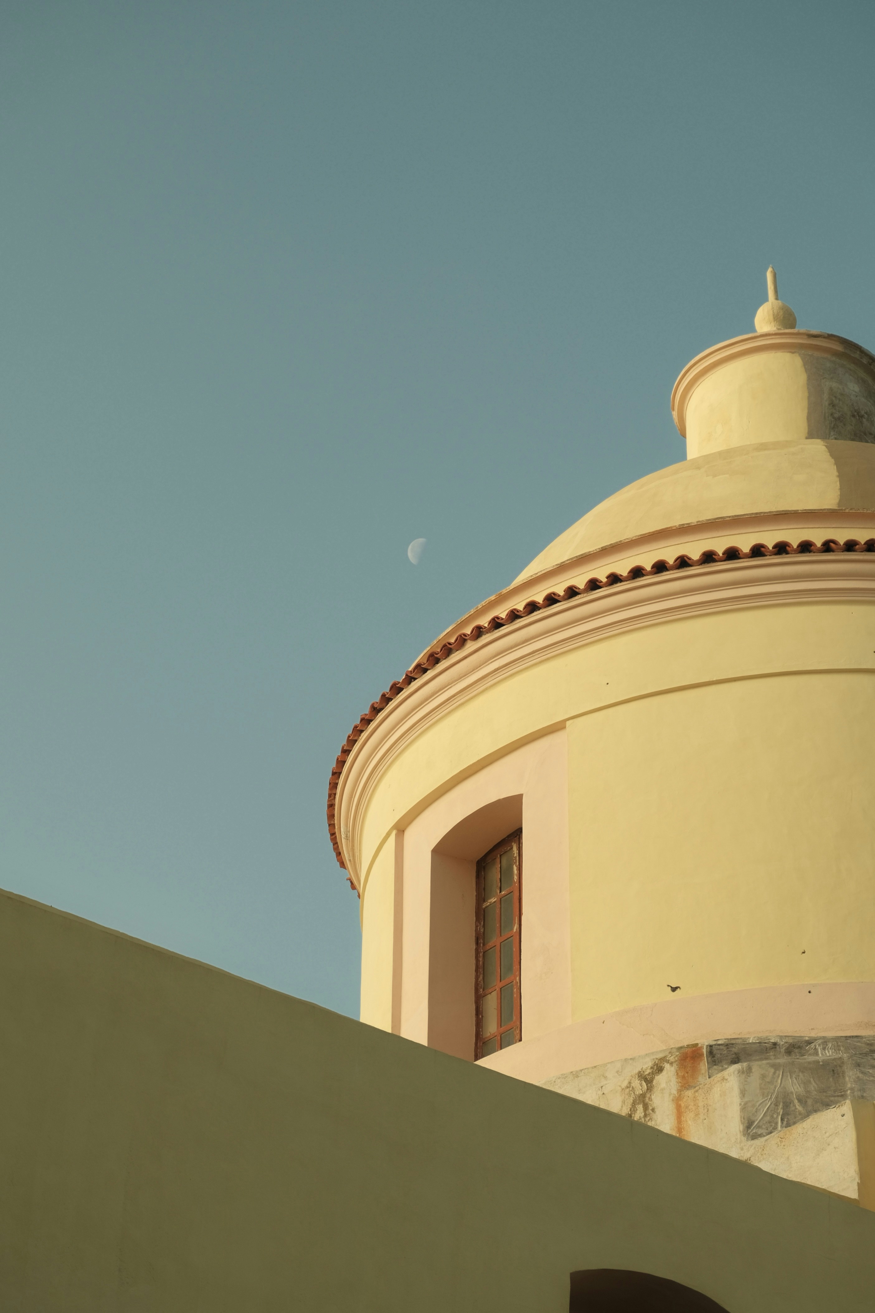 A yellow dome with the moon in the sky.