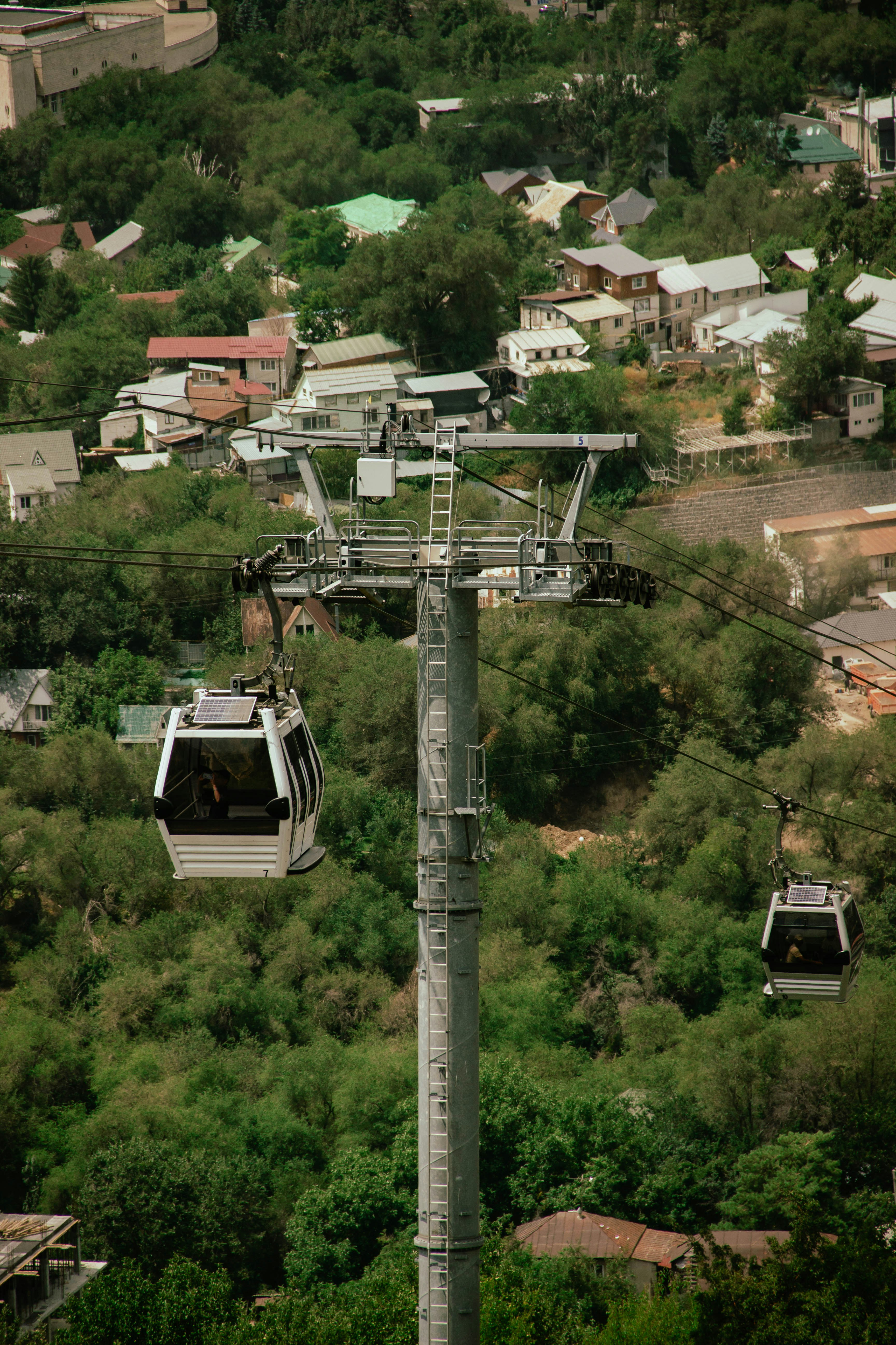 Cable cars traverse over a lush, green landscape.