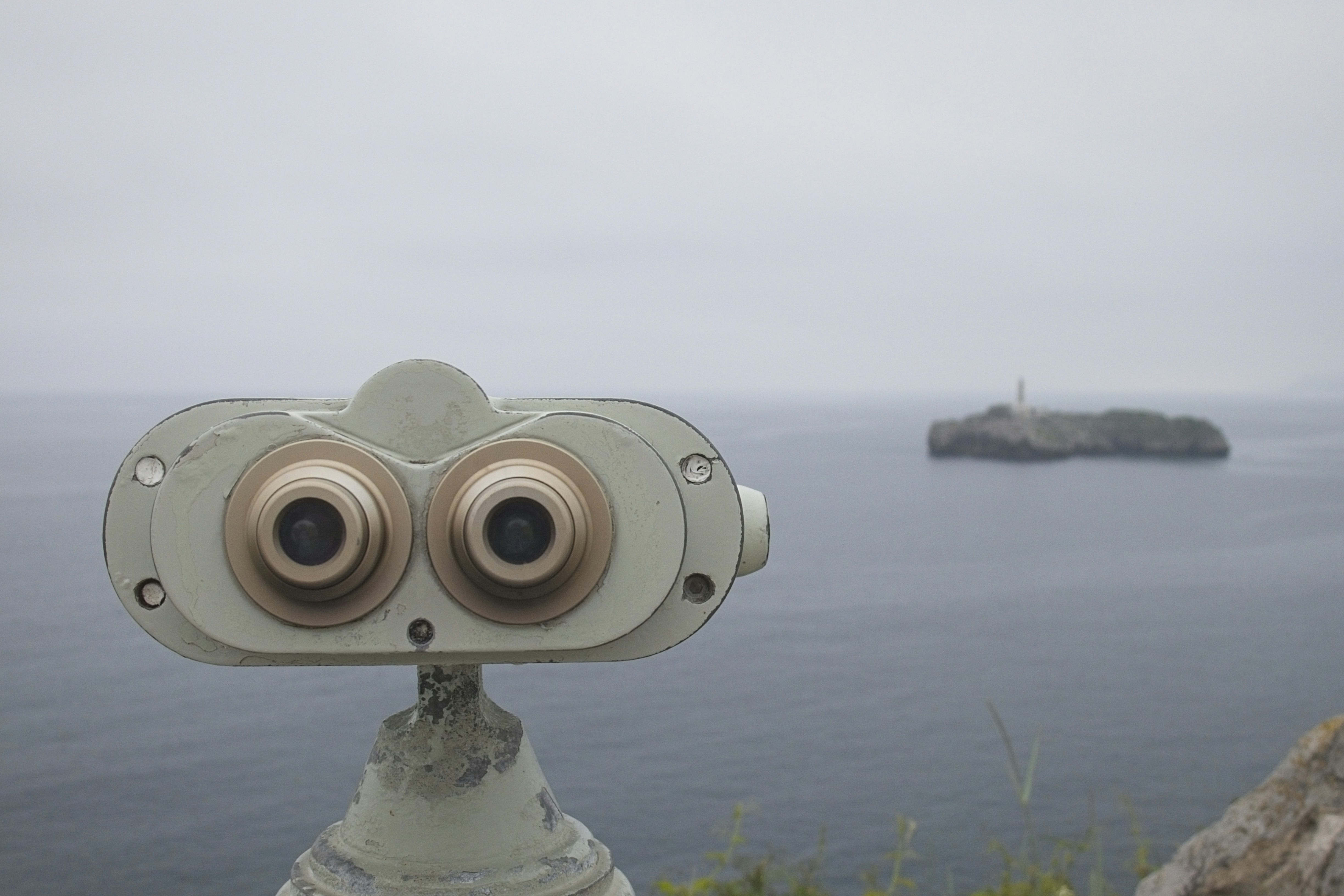 Binoculars focus on a small island in the distance.