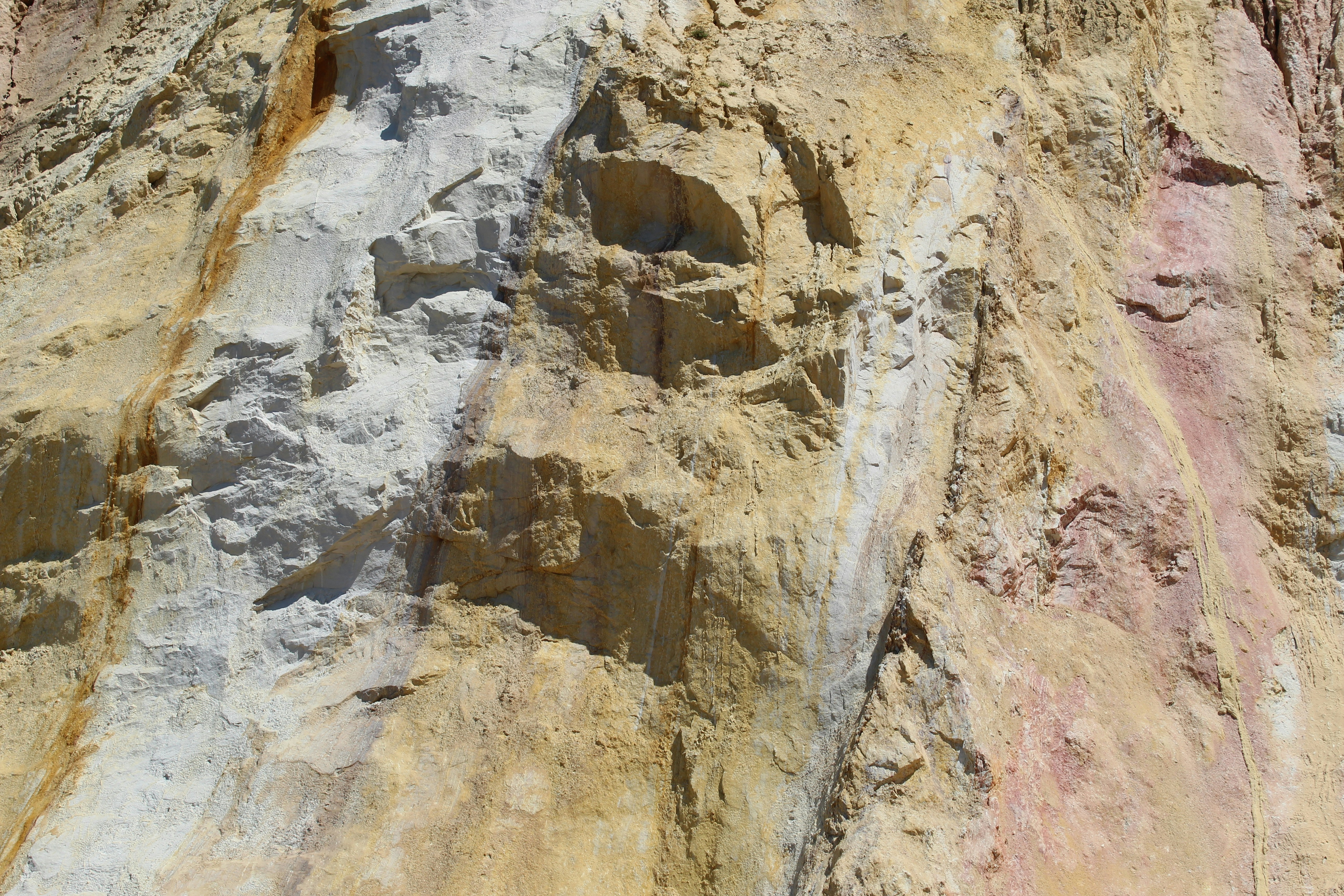 Striking geological formations showcasing vibrant layers of earth tones and textures. The natural erosion creates a visually compelling landscape.