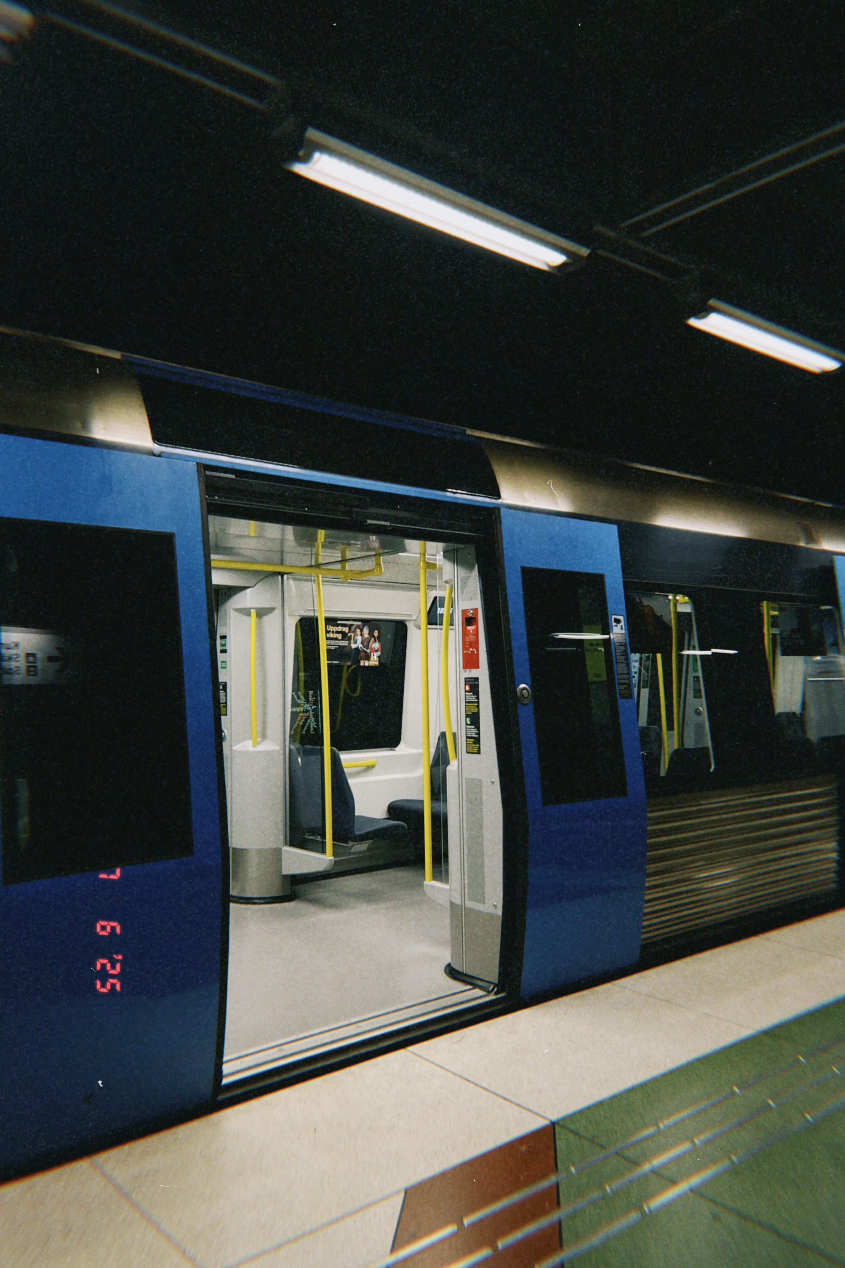 A subway train with open doors sits in a station.