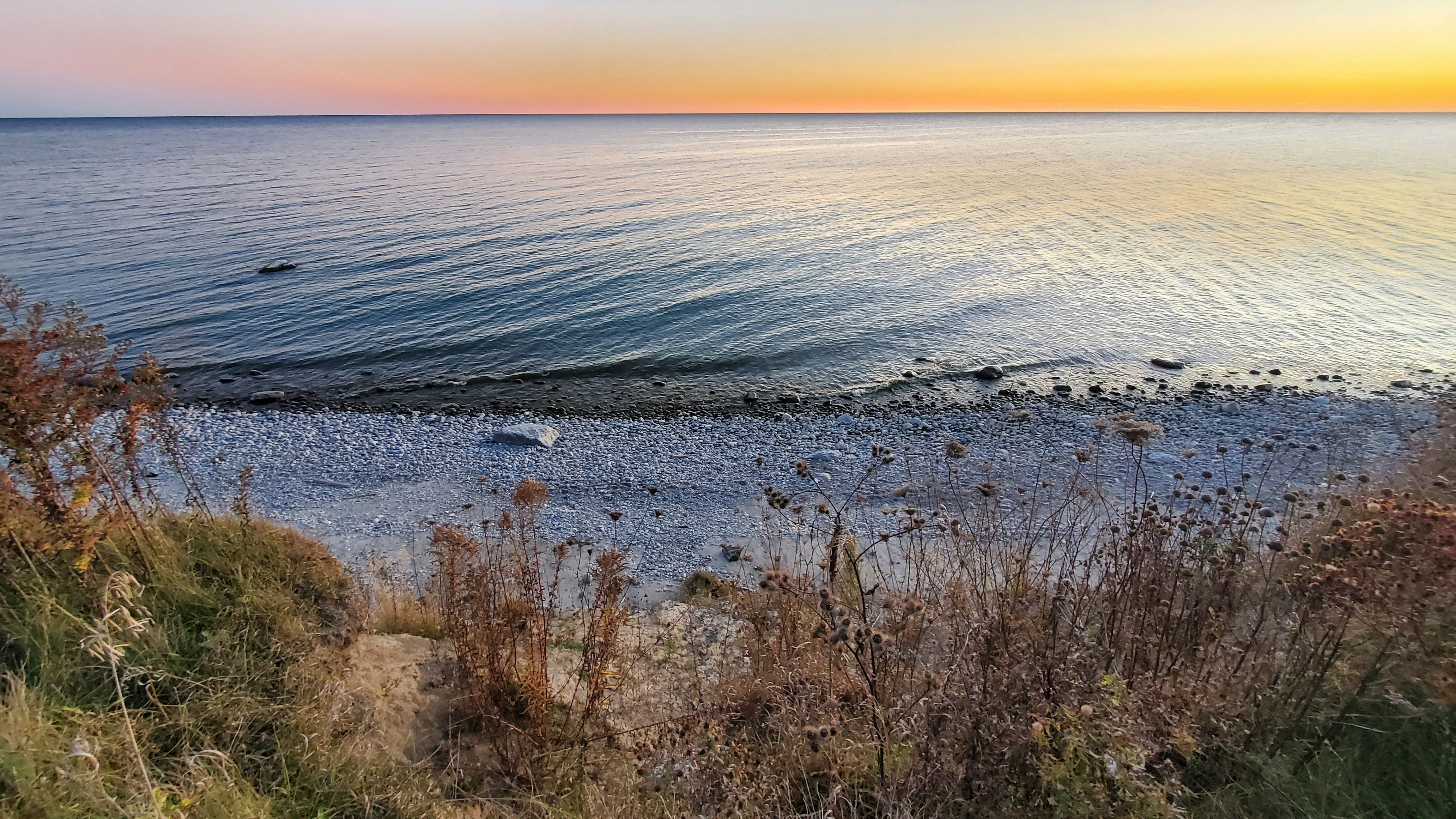 Autumn Sunset Over Lake Ontario at Lakebreeze Park in Newcastle, ON | The sea meets a beach at a colorful sunset.