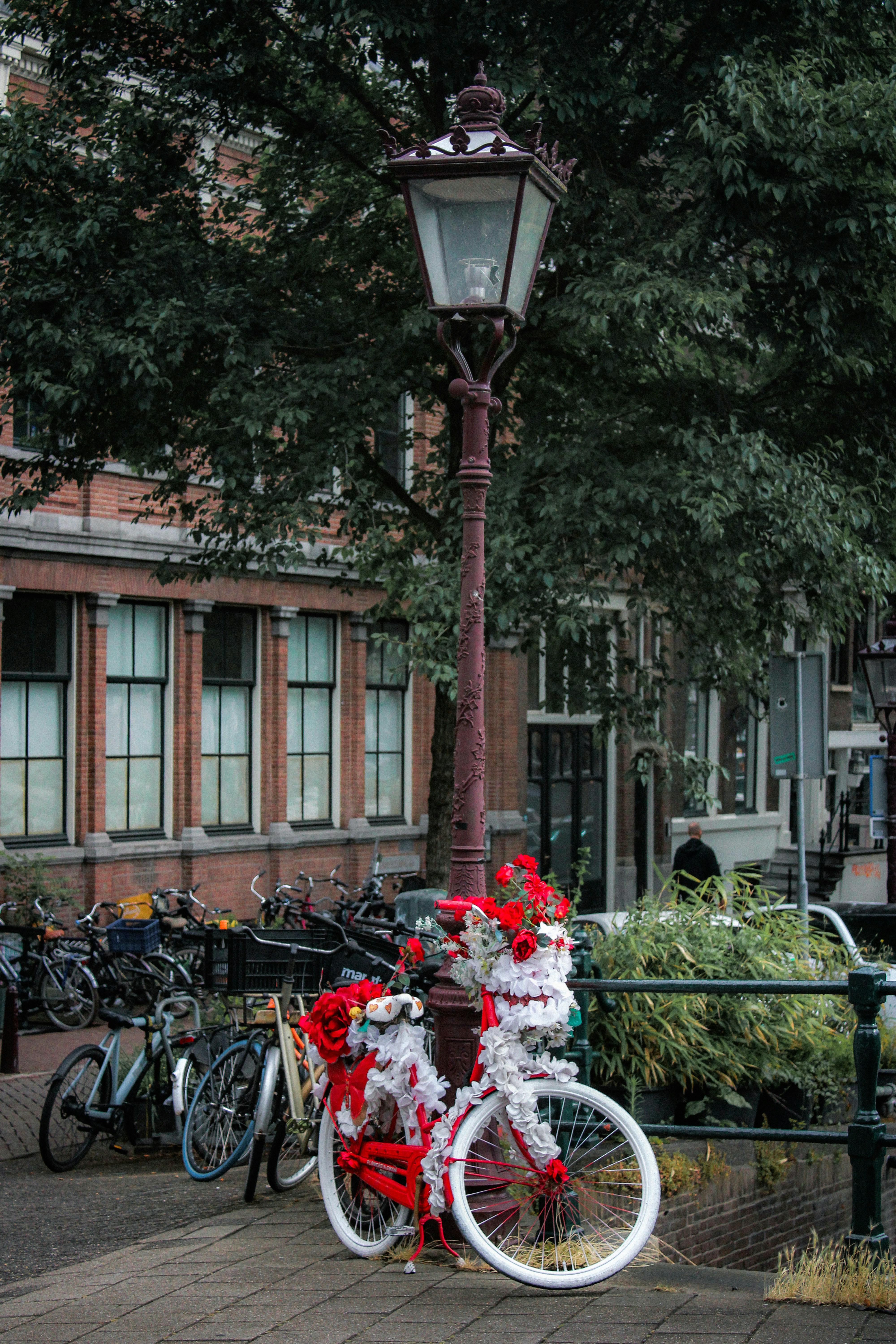A decorated bicycle leans against a vintage lamppost.