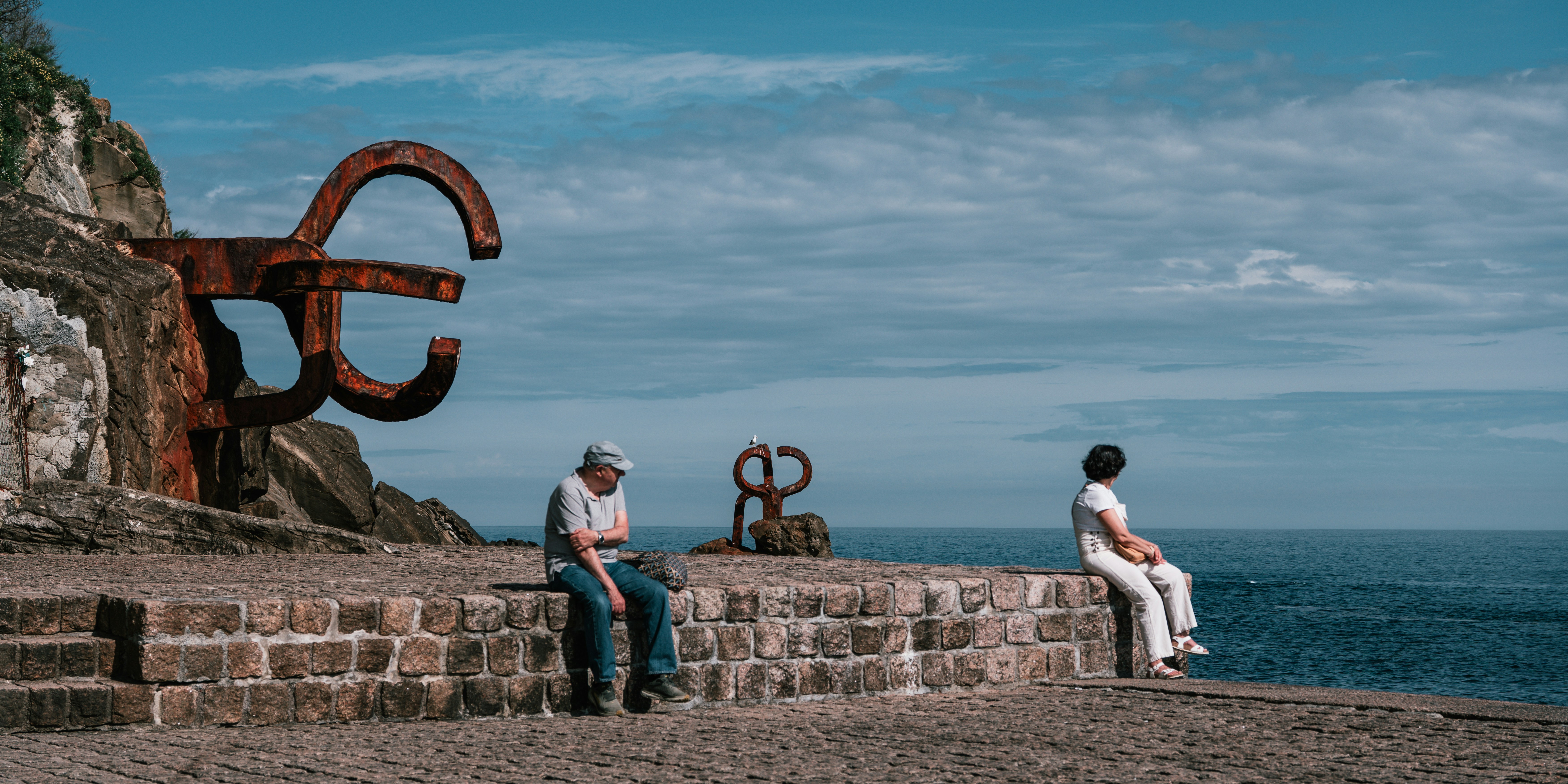 Seaside Couple and Rusted Sculptures on the Breakwater