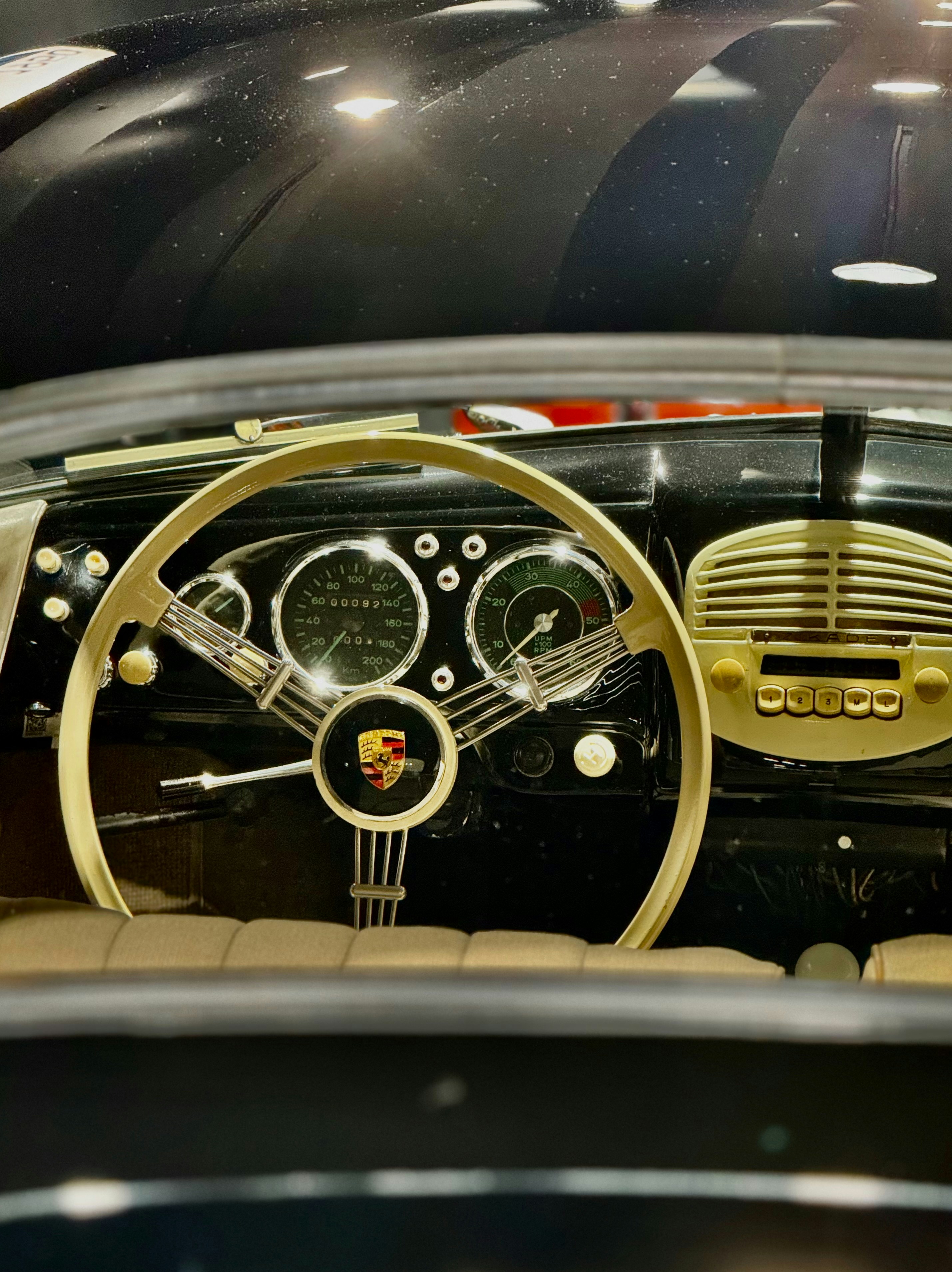Vintage Porsche dashboard showcasing intricate dials, a polished steering wheel, and retro controls. A glimpse into automotive history.