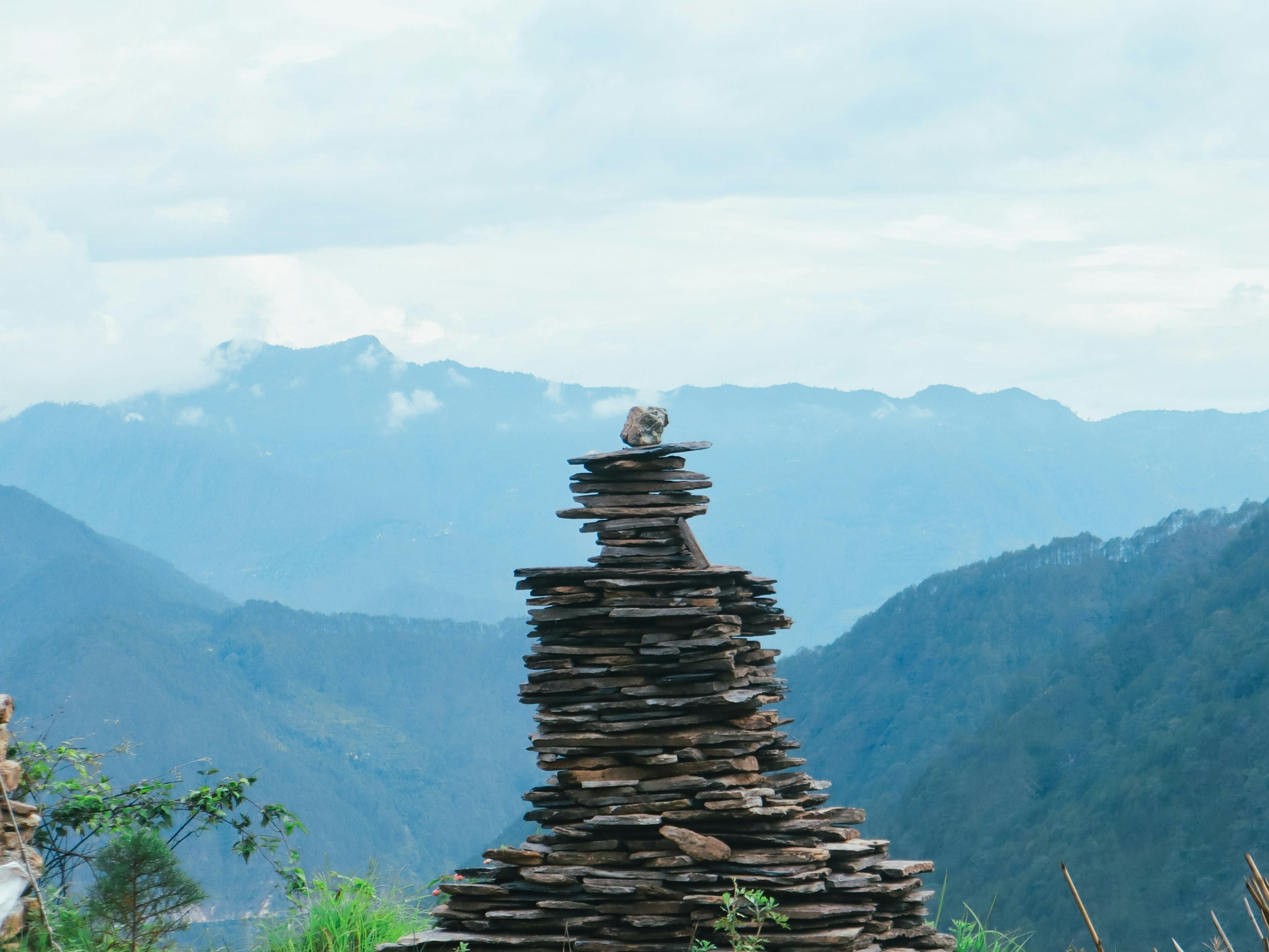 Stone stack overlooks a mountain range.