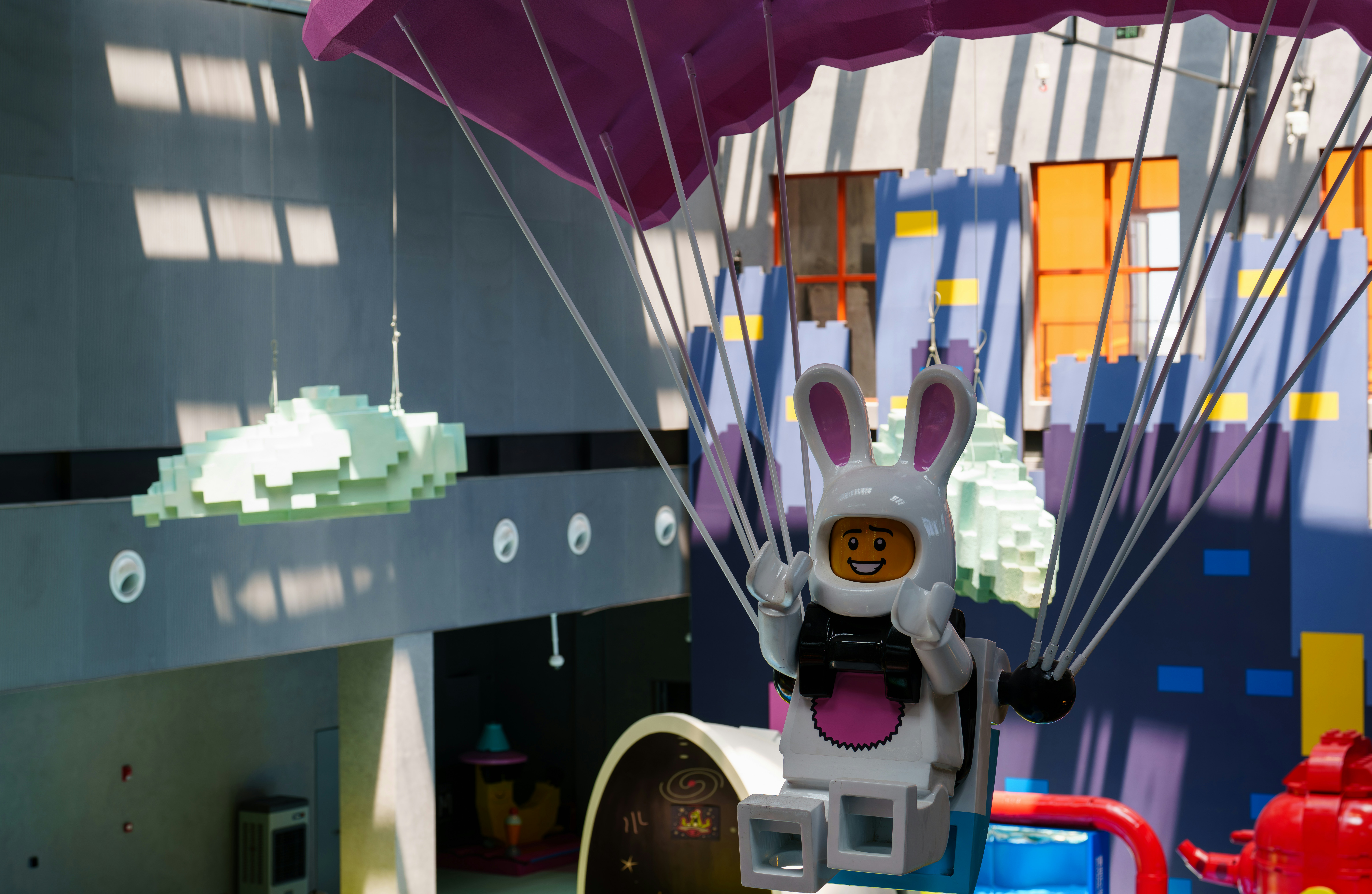 Peace Sign over Neon Heights: A LEGO Bunny Rides an Indoor Parachute