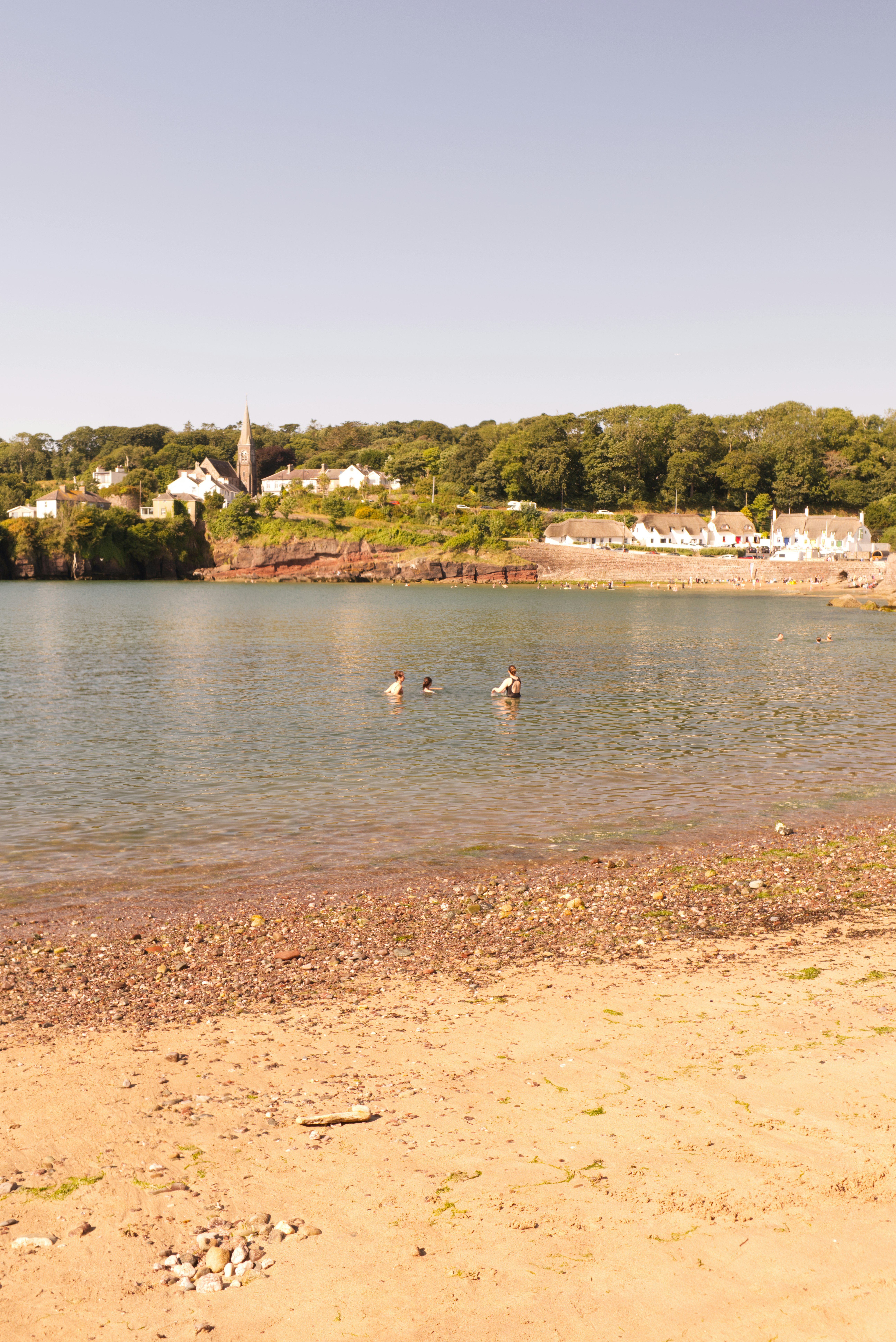 Cove of Quiet Light: Swimmers and a Village Silhouette