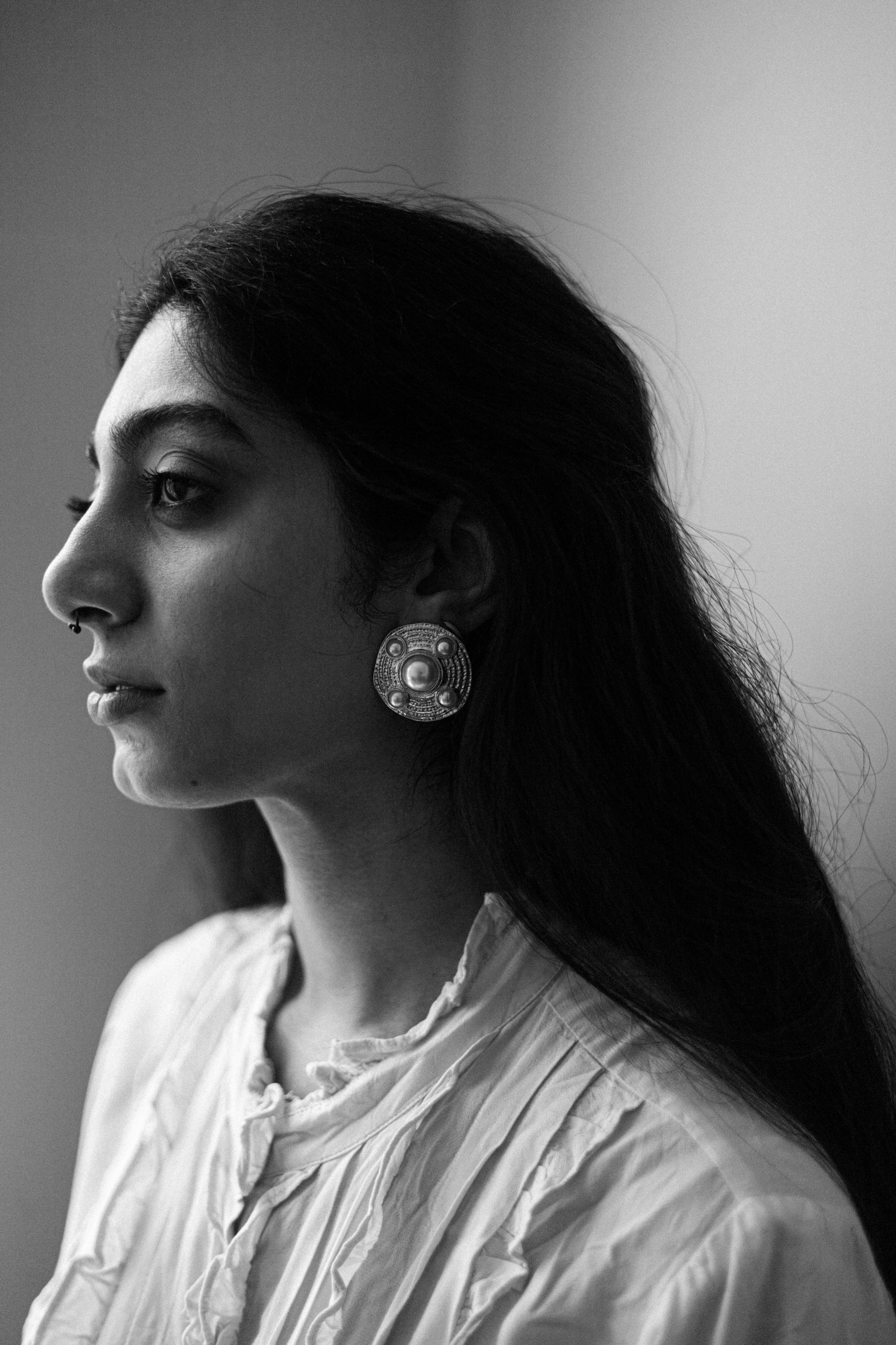 A woman poses in a profile, wearing an earring. photo – Free Portrait ...