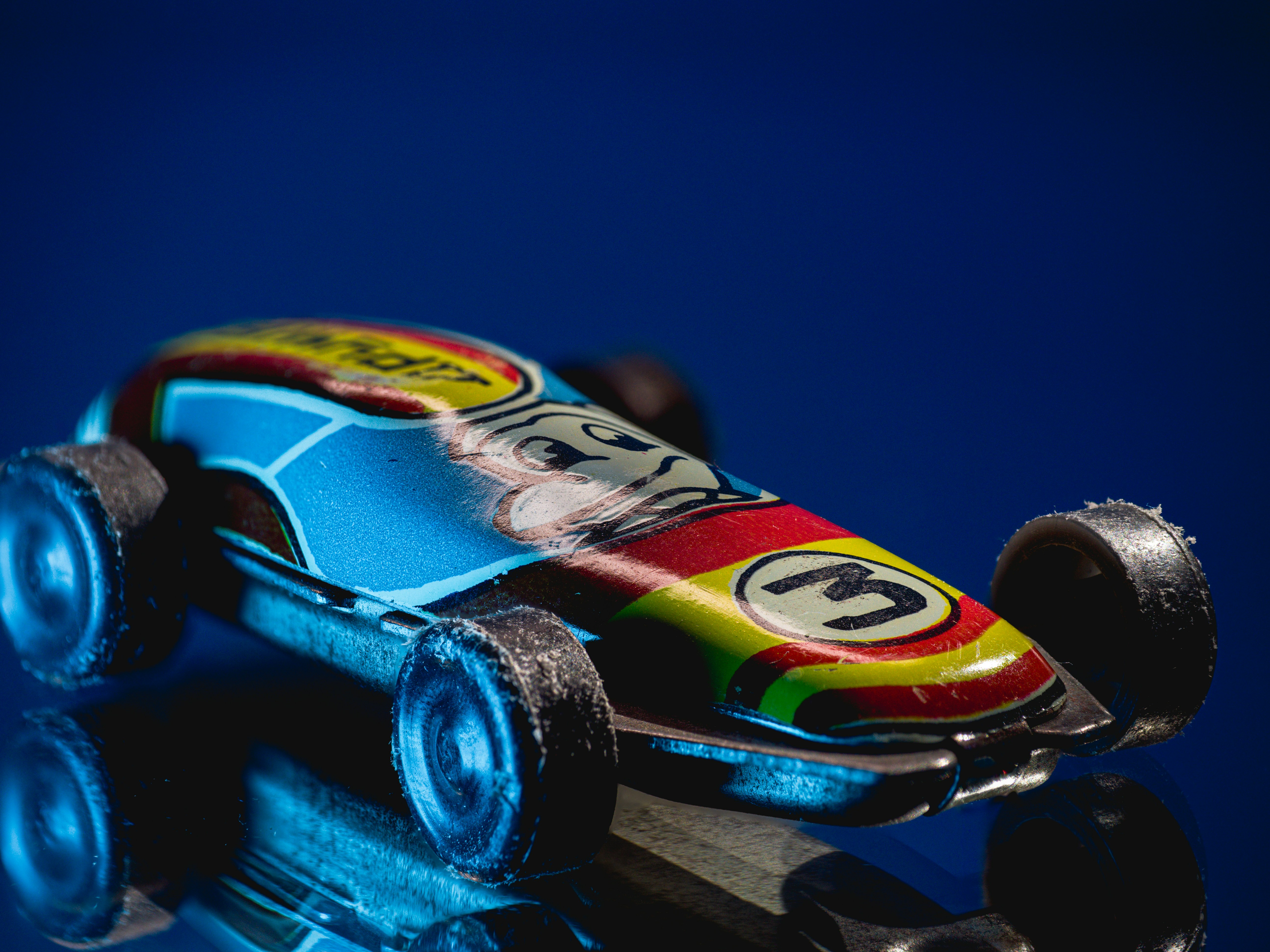 Chrome-dusted toy racer under cobalt glow