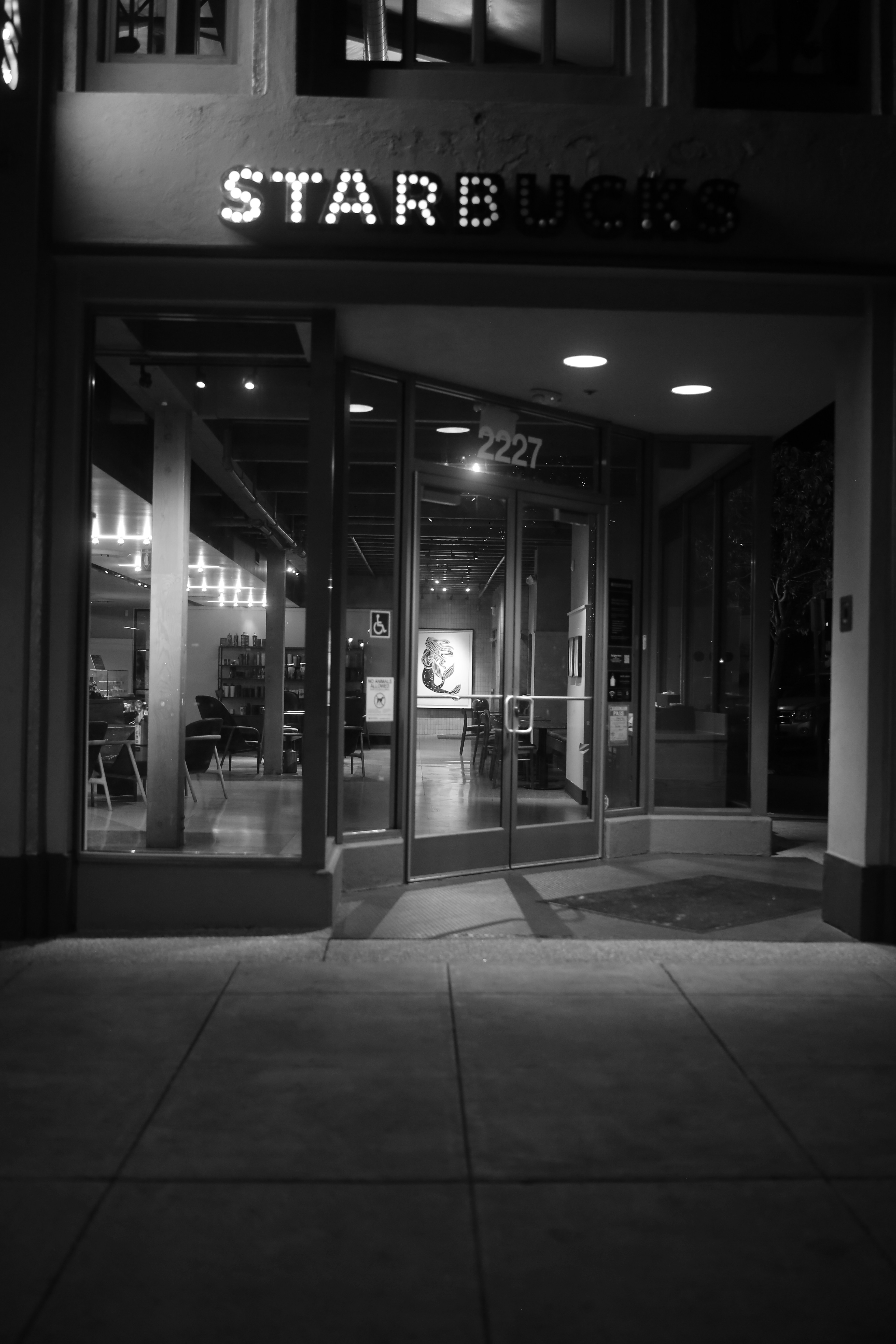 Illuminated entrance of a Starbucks café showcasing a warm interior ambiance and modern decor.
