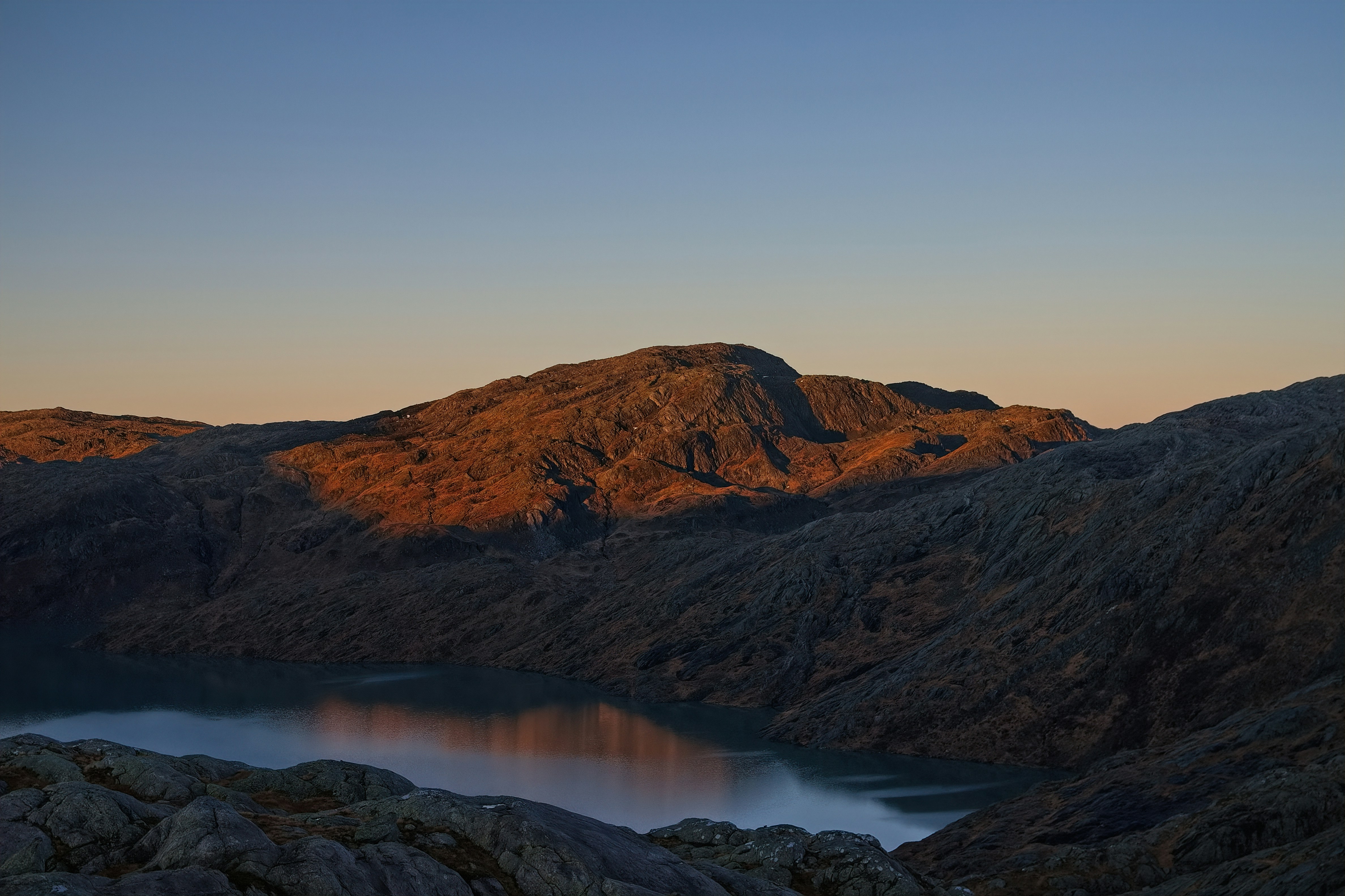 Sunrise over Folgefonna National Park. | Sunrise illuminates a mountain range and lake.
