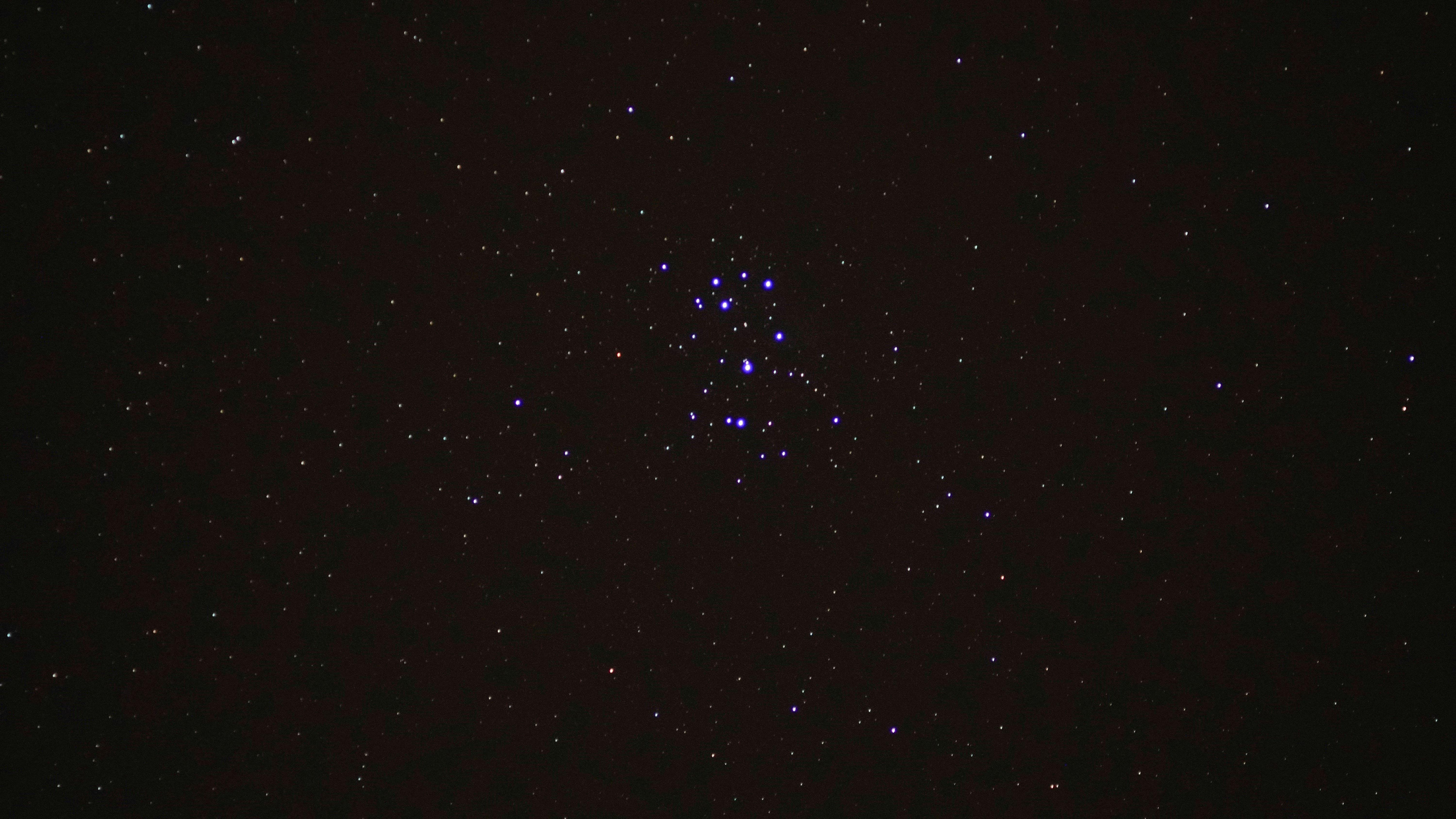 A cluster of stars shines brightly in the night.