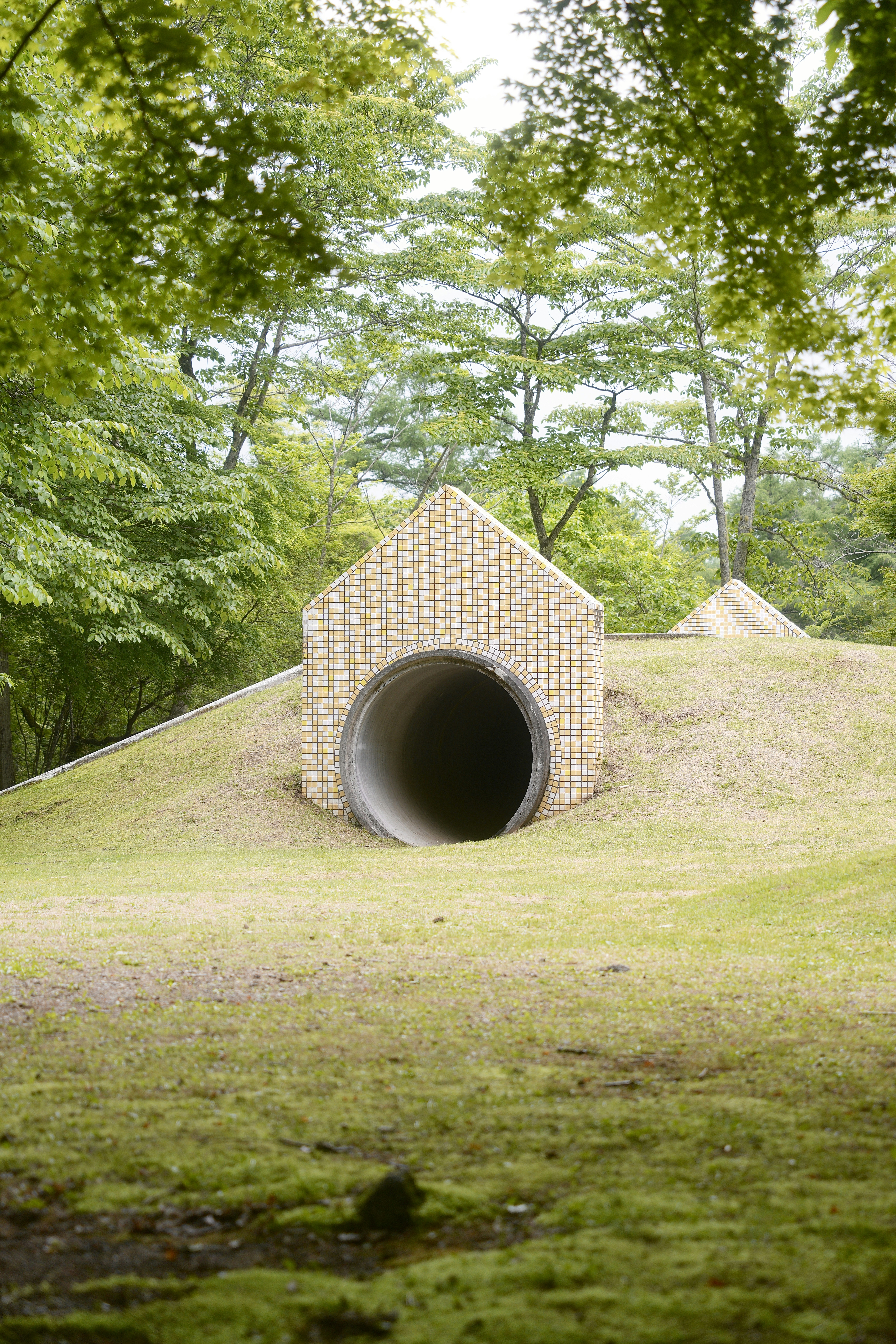 Yamanakako | A tunnel entrance emerges from a grassy hill.