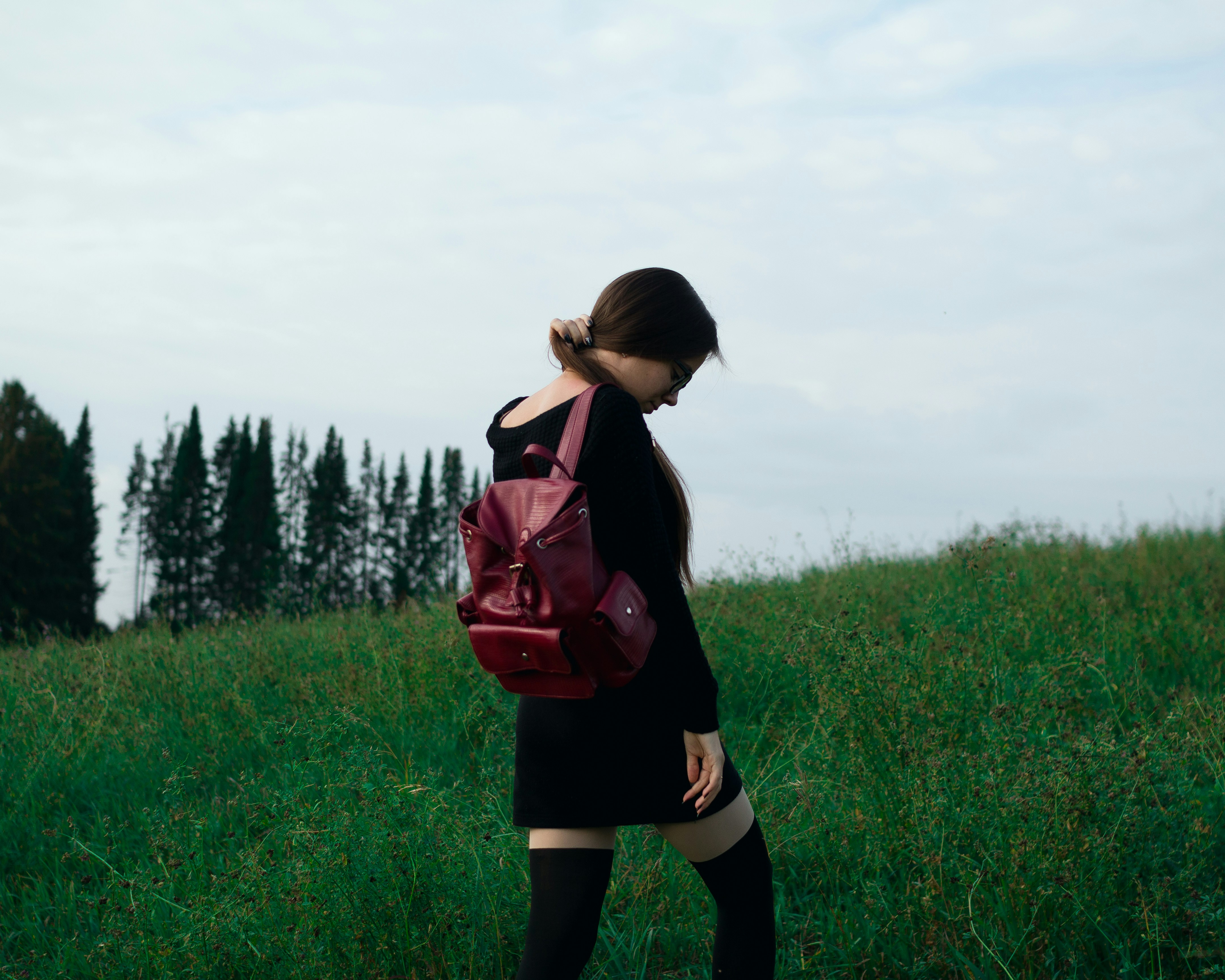 A person walks through a grassy field.