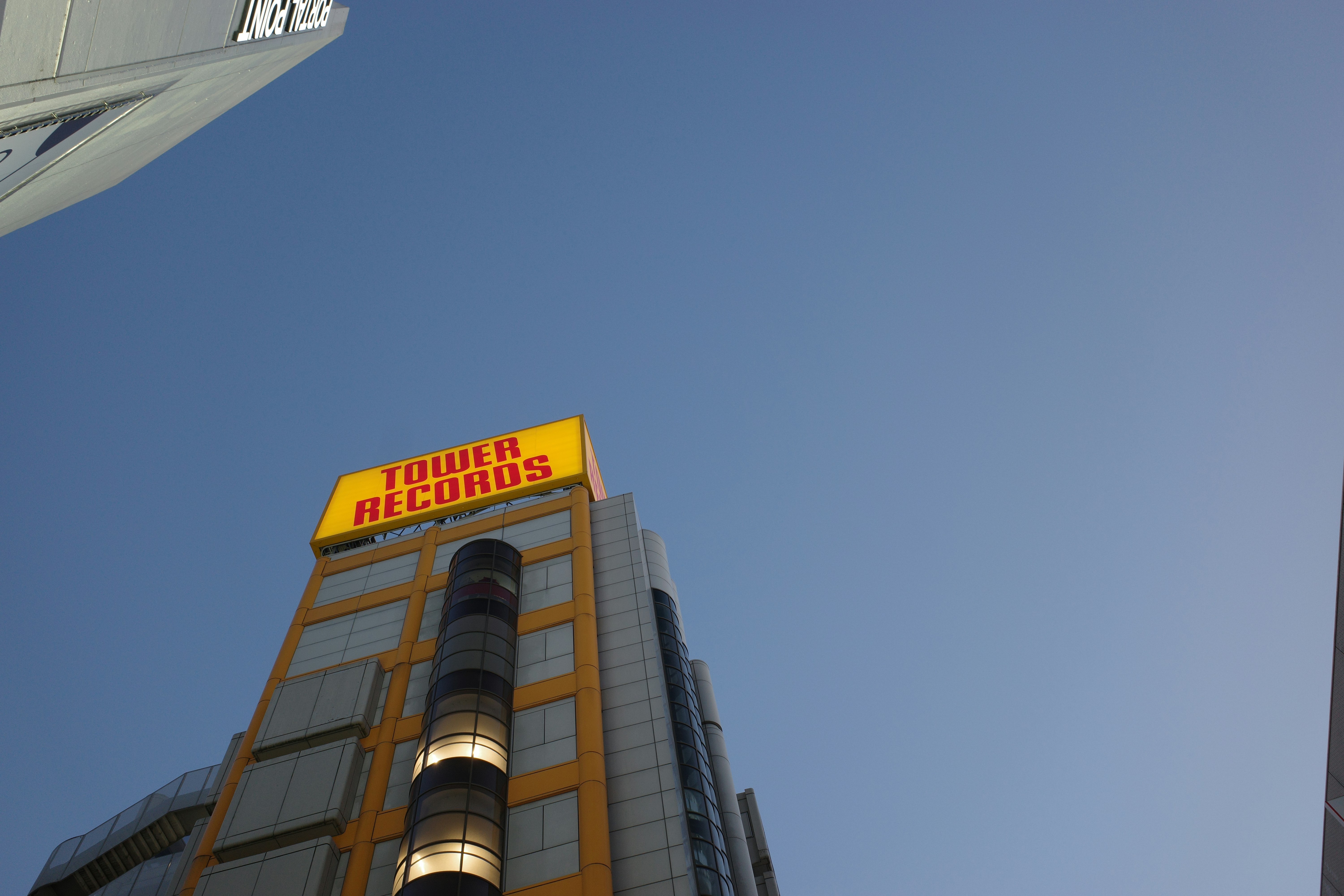Tower records building under a clear blue sky.