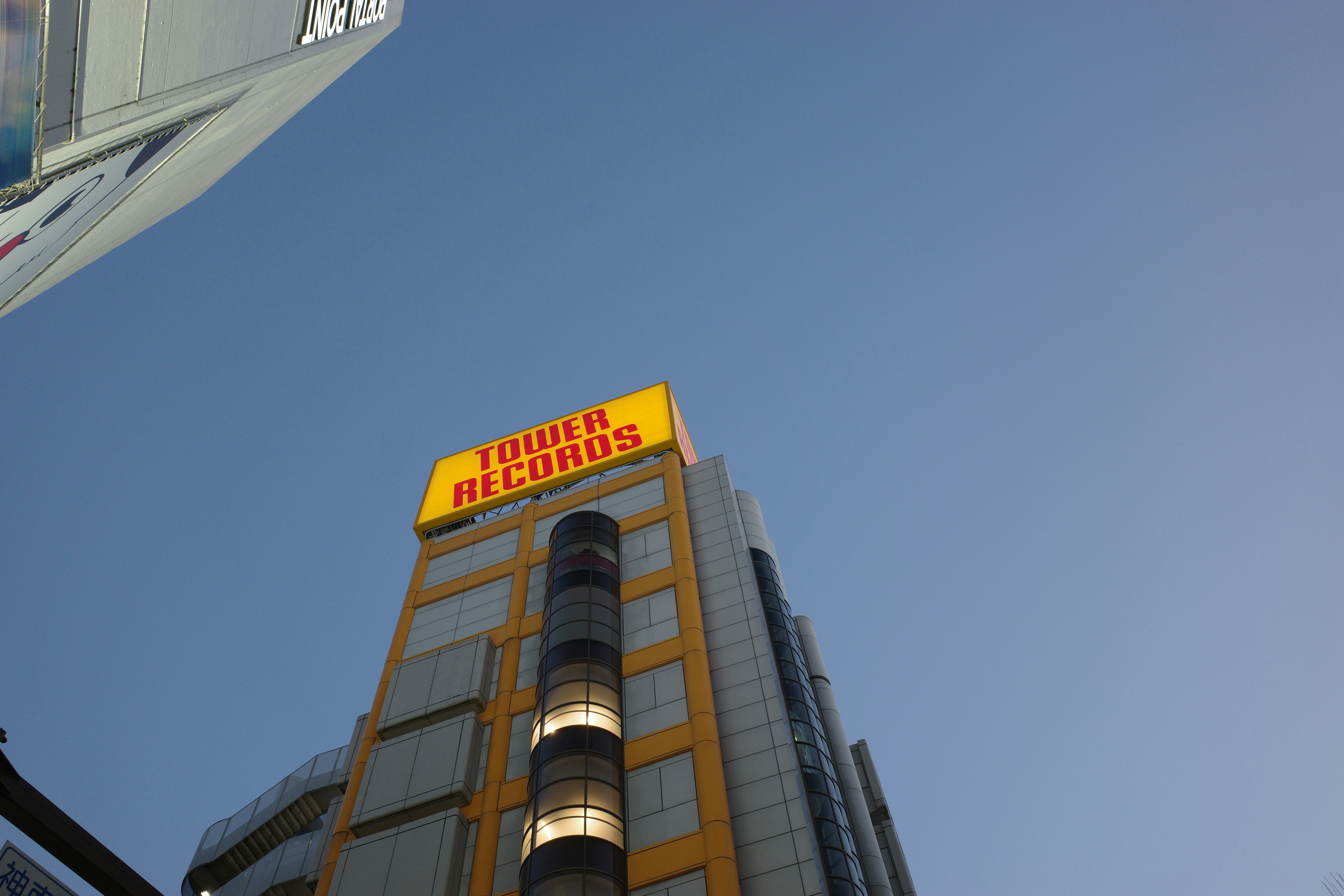 Vibrant Tower Records sign towering against a clear blue sky, showcasing urban architecture and cultural significance.