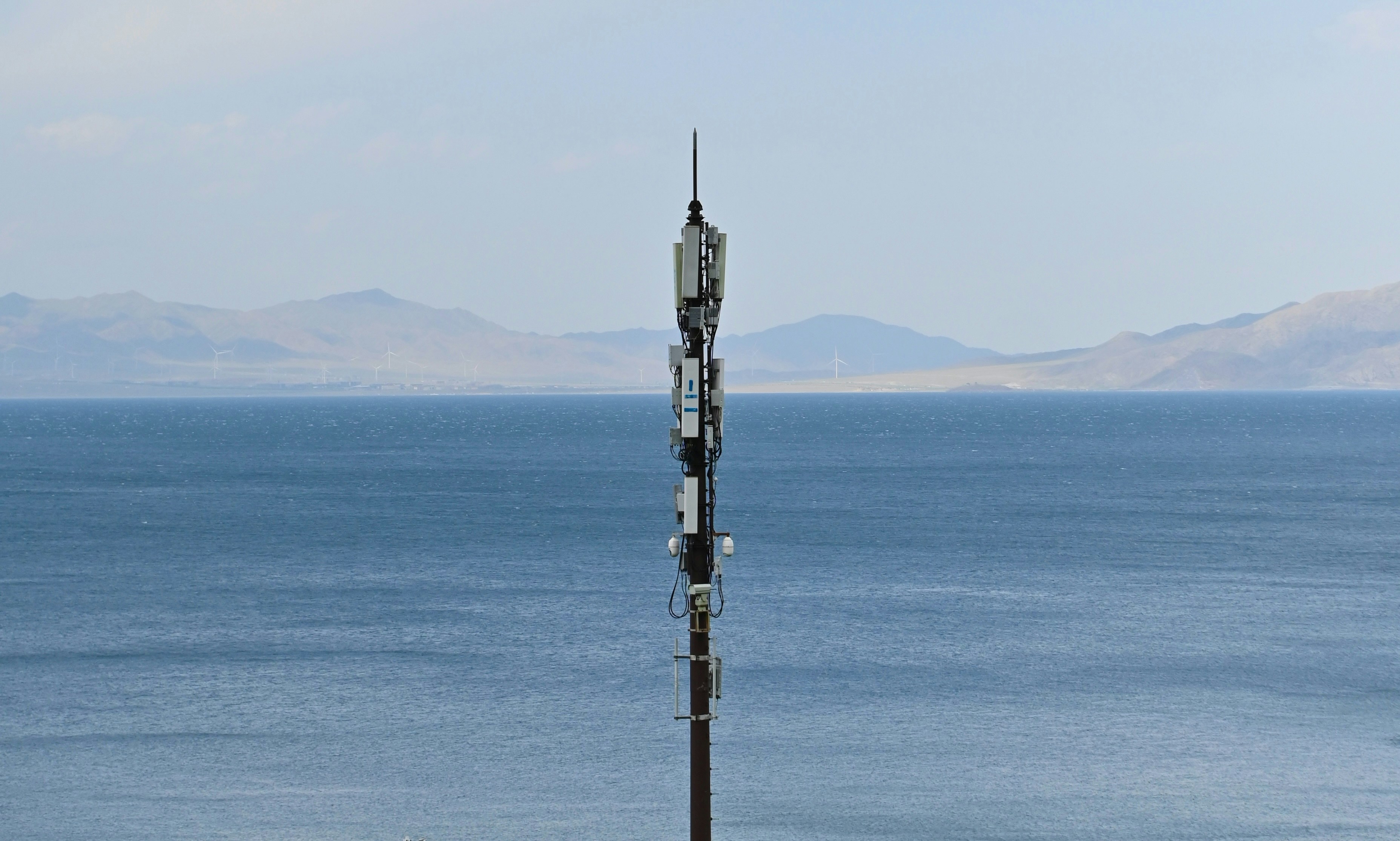 Vertical Antenna Sentinel Against a Calm Sea Horizon