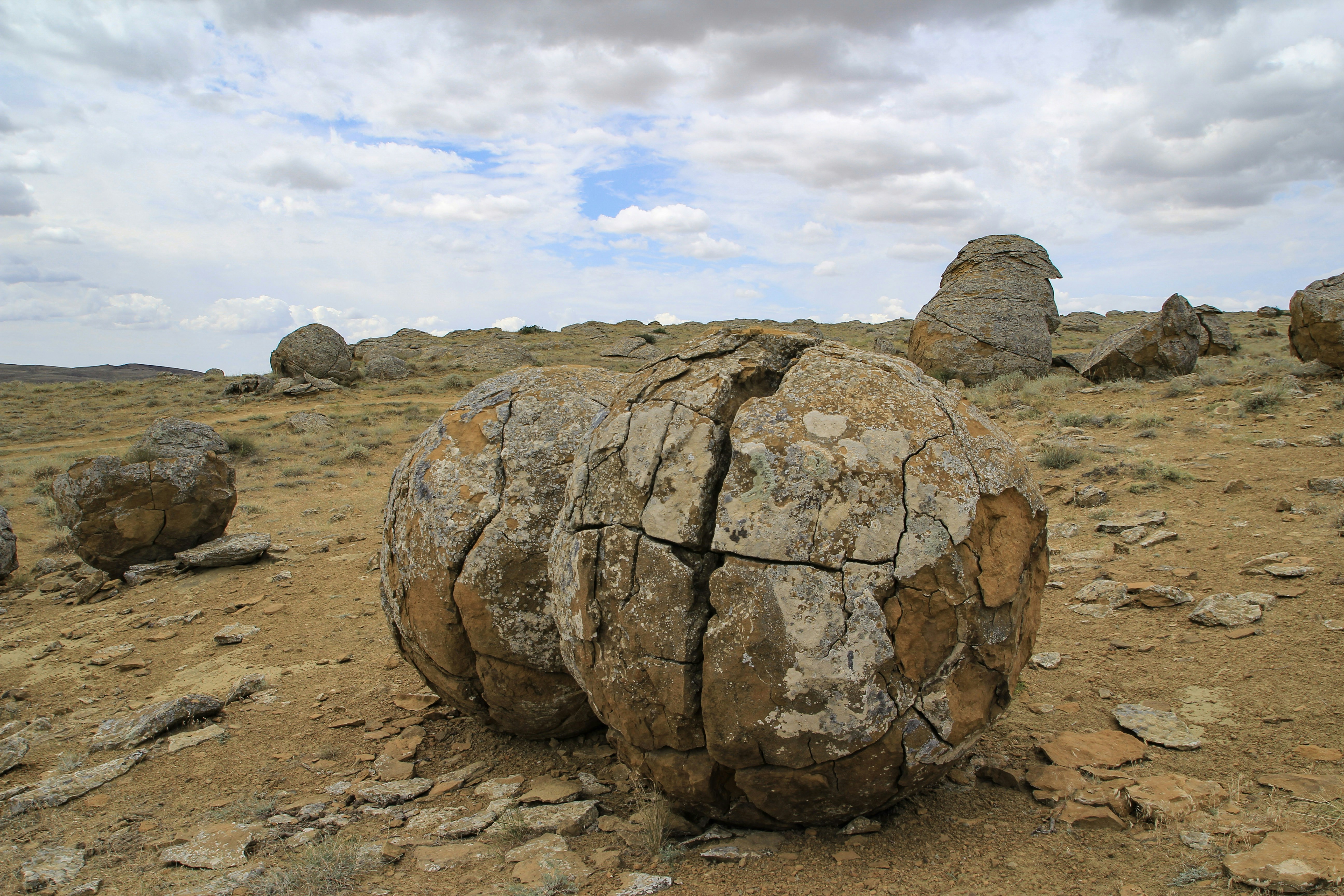 Large, cracked rocks sit in a desolate landscape.