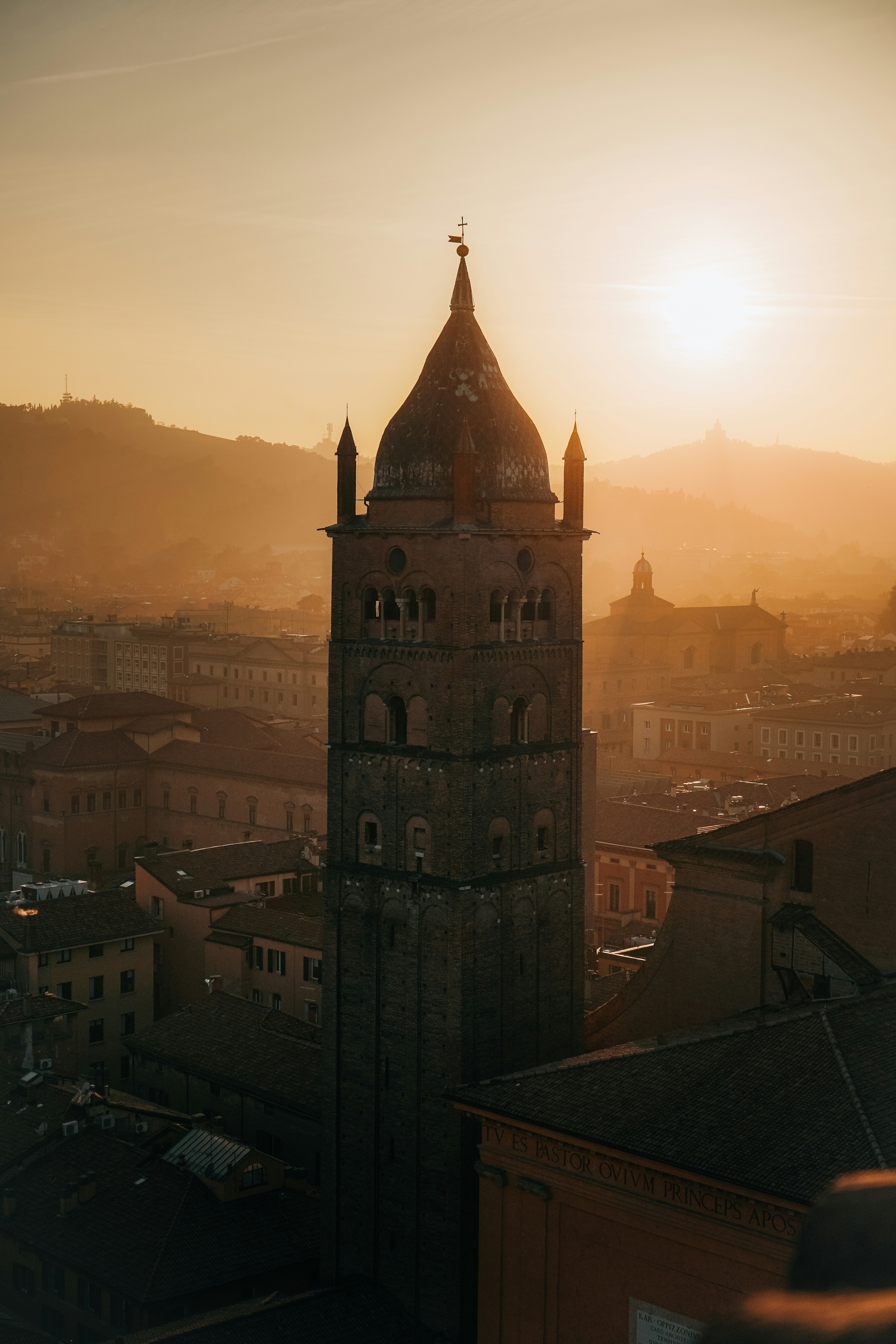 Sunset bathes a tall, historic tower.