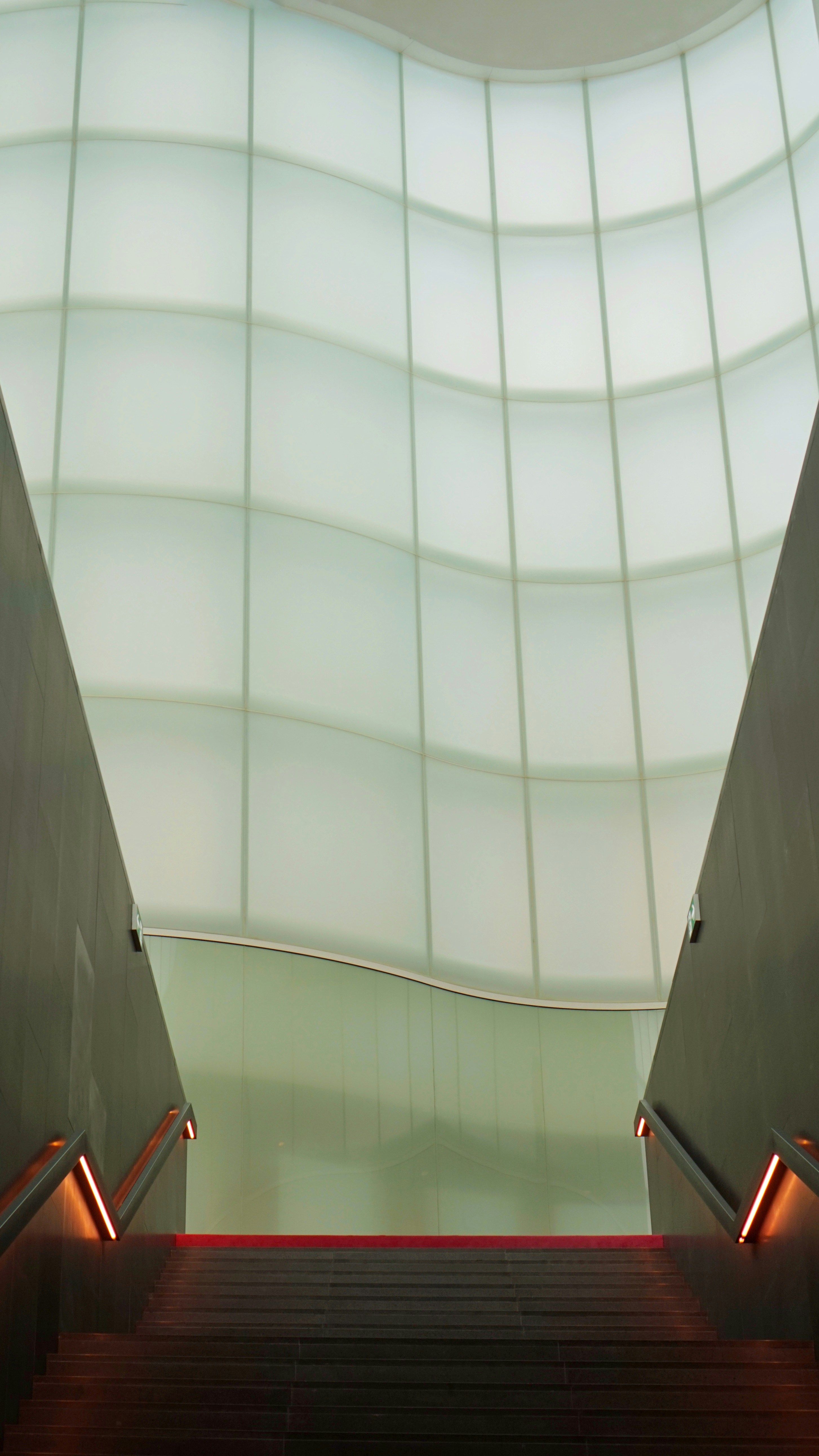 Staircase leading up to an illuminated, wavy ceiling. photo – Free ...