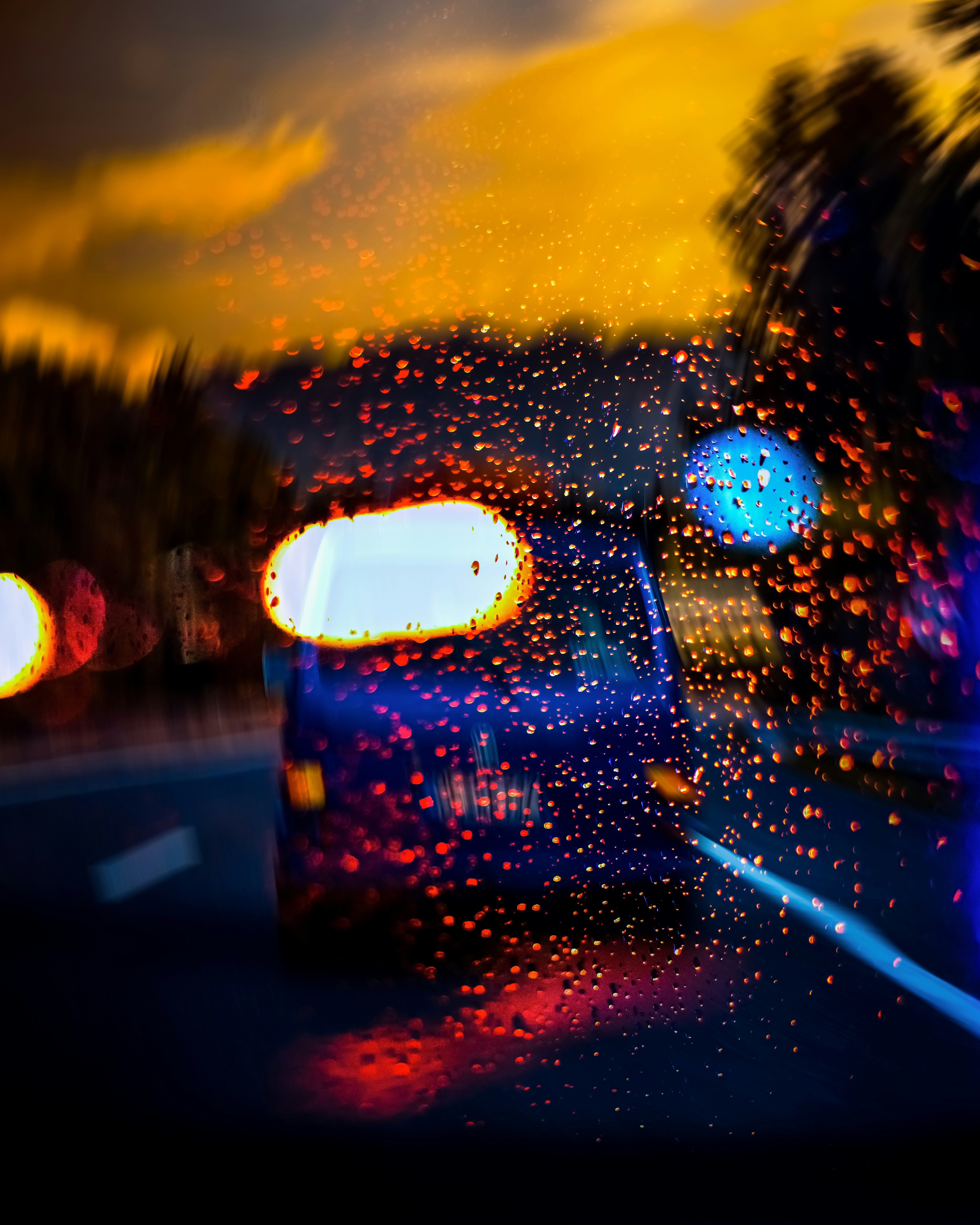 Raining night: car lights blur in the darkness.