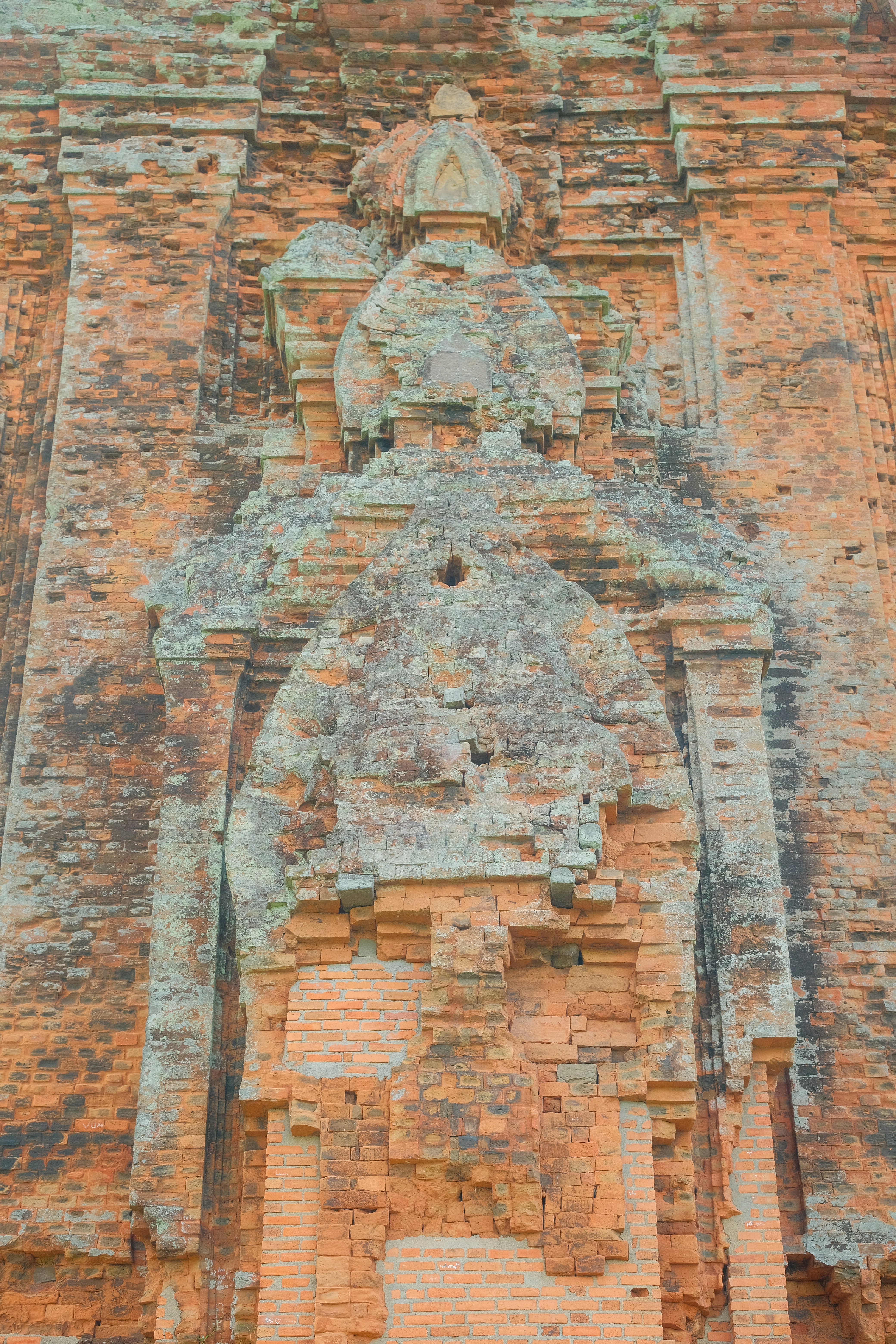 Ancient brick wall features ornate carvings.