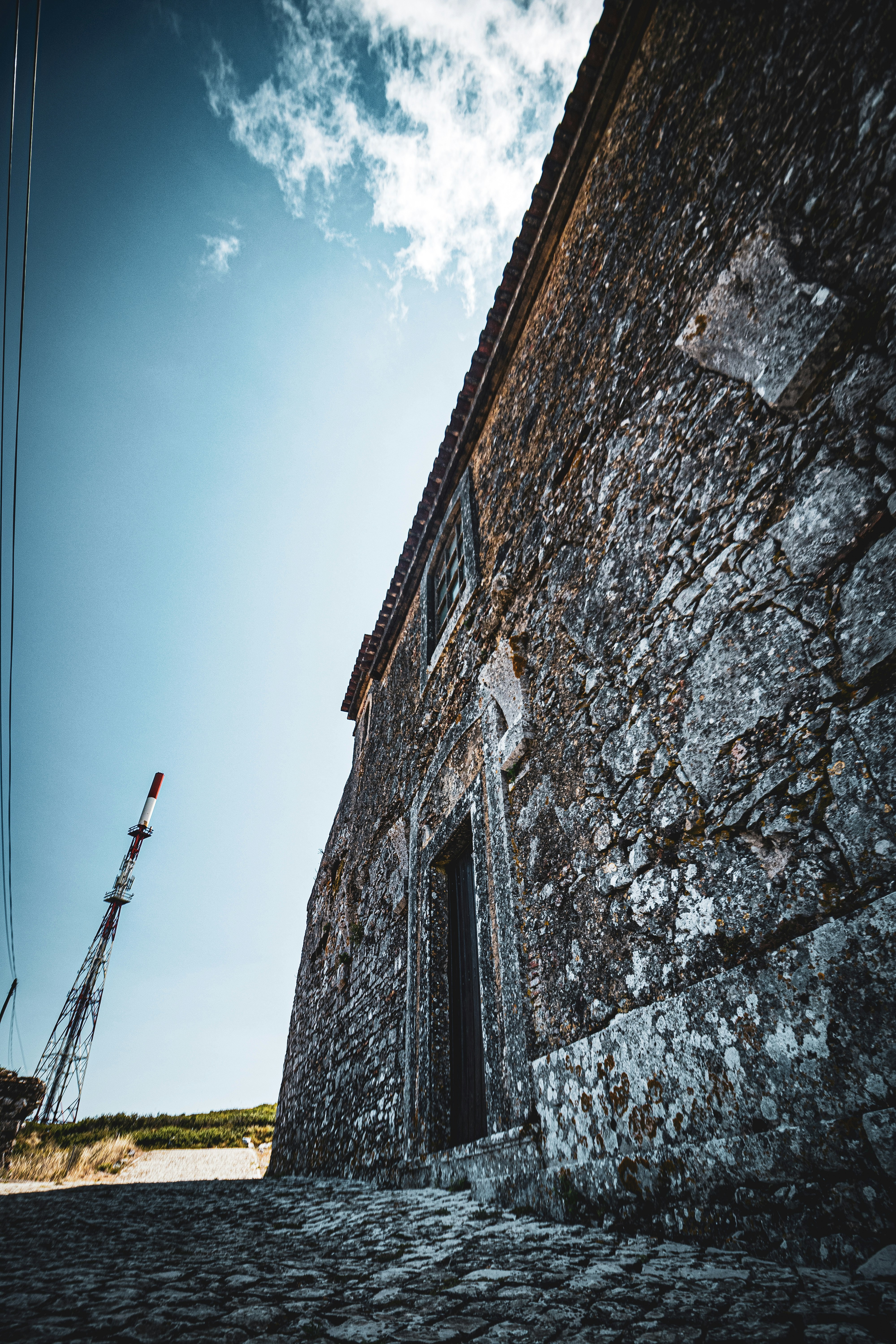Old stone building stands under a blue sky.